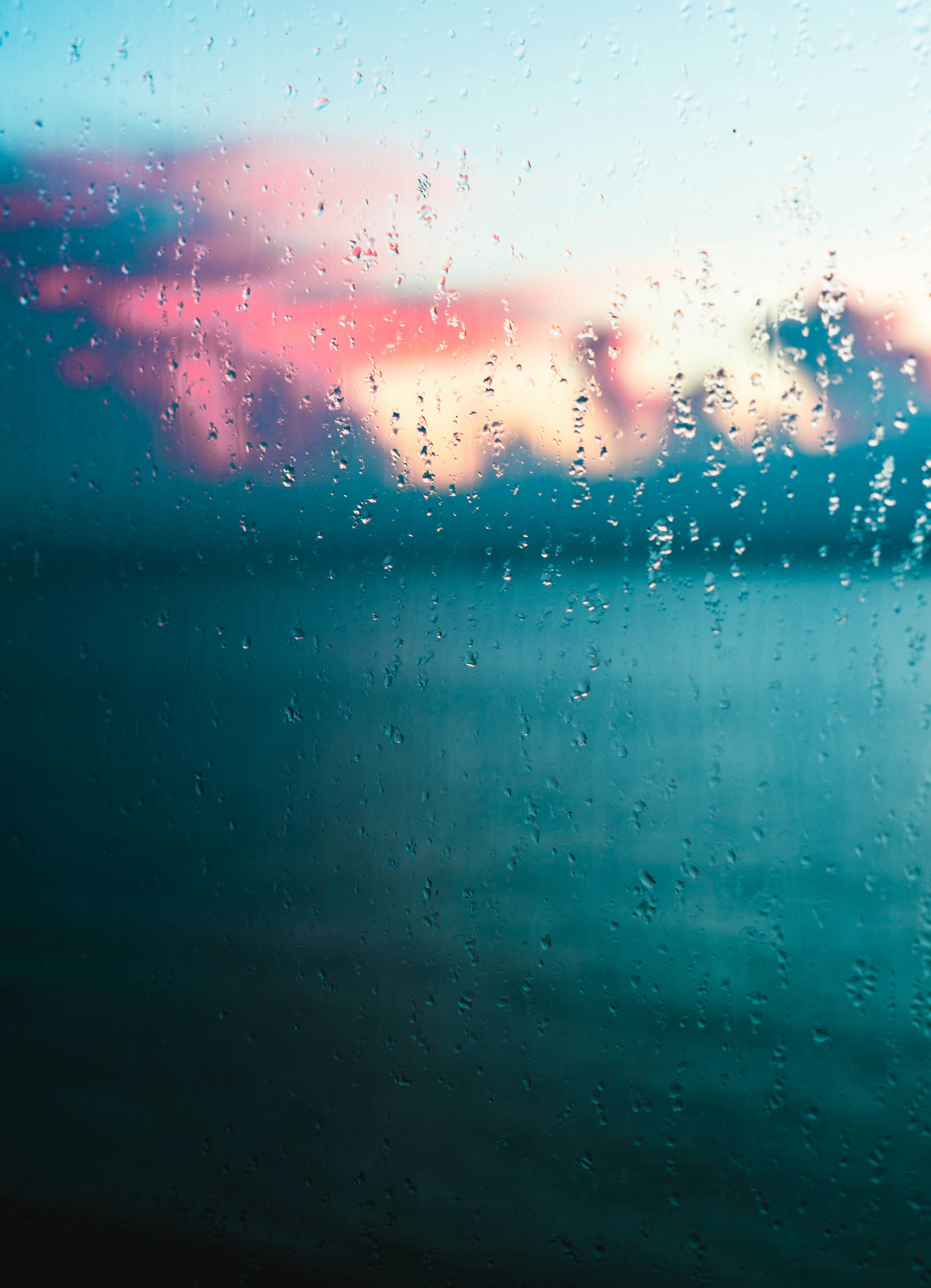 Rain-Dotted Glass at Dusk: A Quiet Sea Beyond