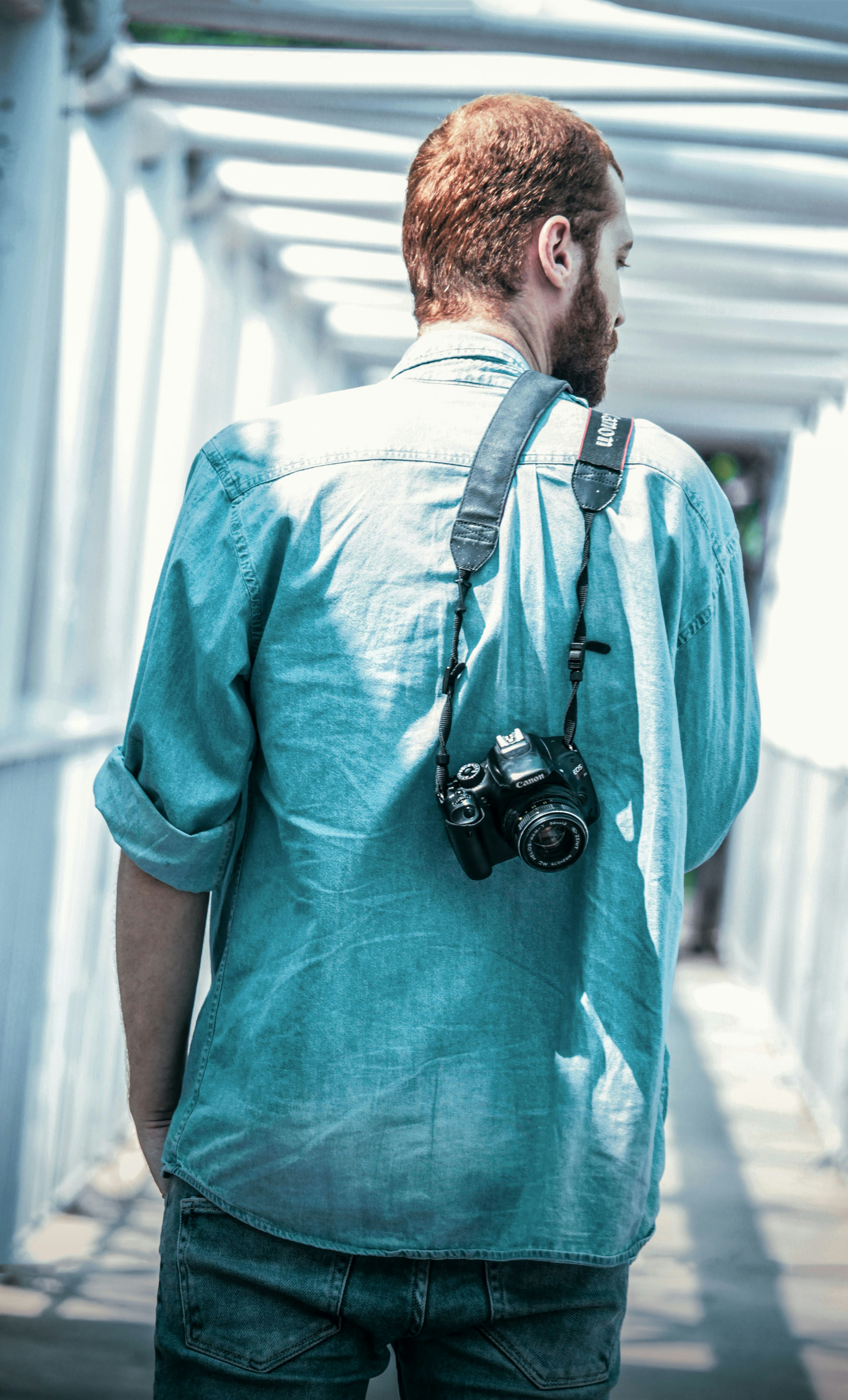 Denim and the Hanging Lens: Street Photographer on a Sunlit Bridge