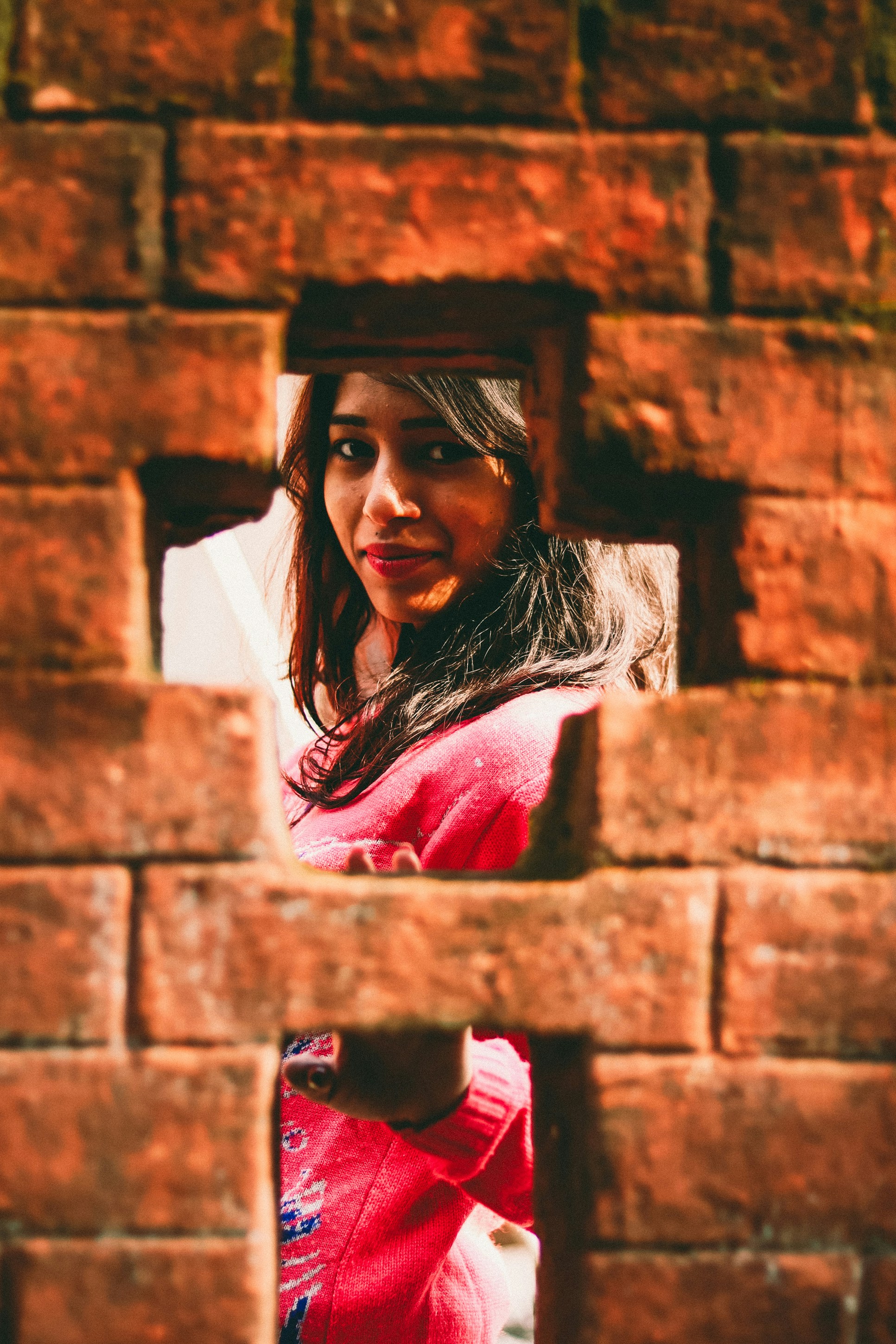 Through the Brick Window: A Portrait Framed by Rustic Openings