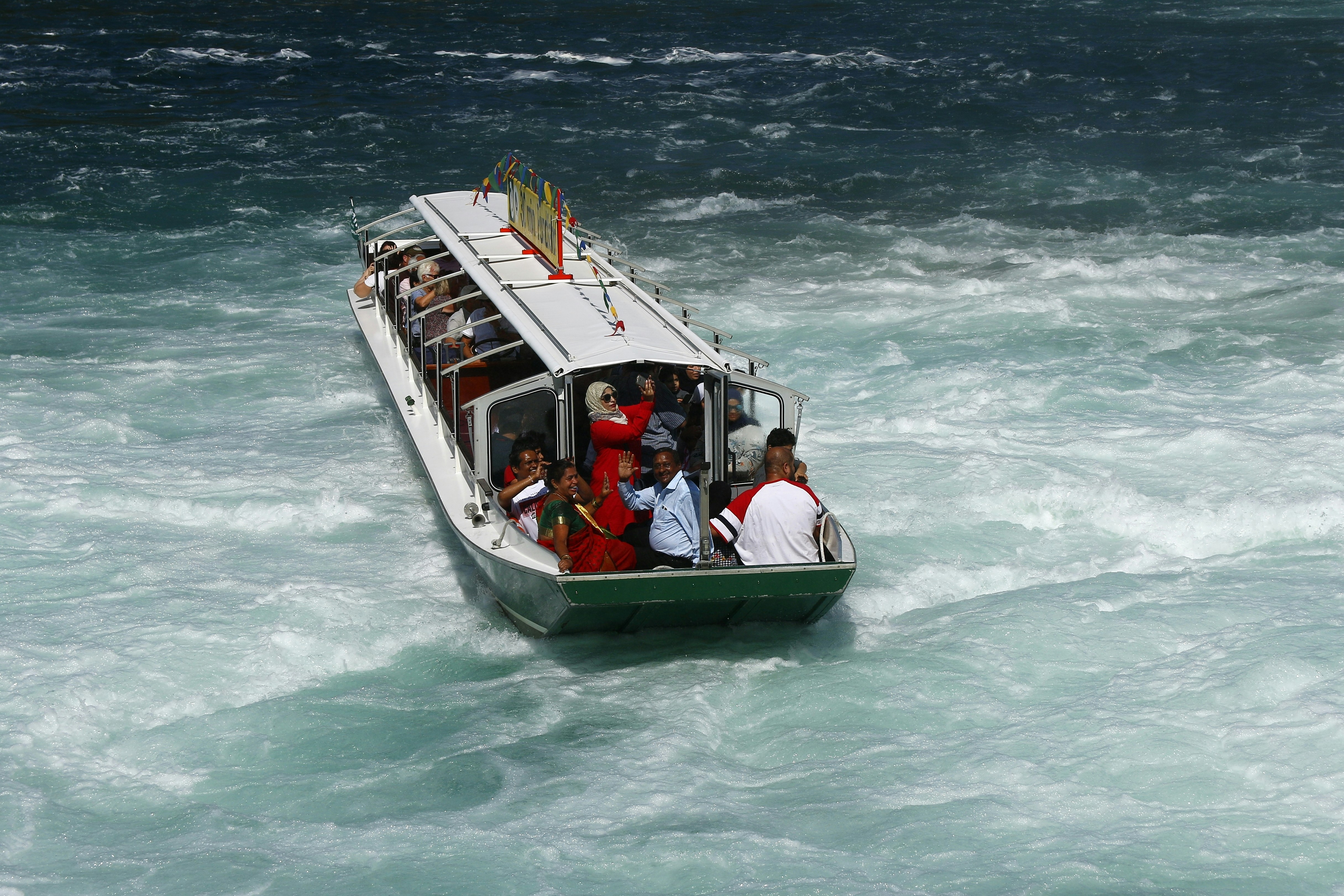 Rushed Passage: Passengers Ride a White-Walled Boat Through Turquoise Rapids