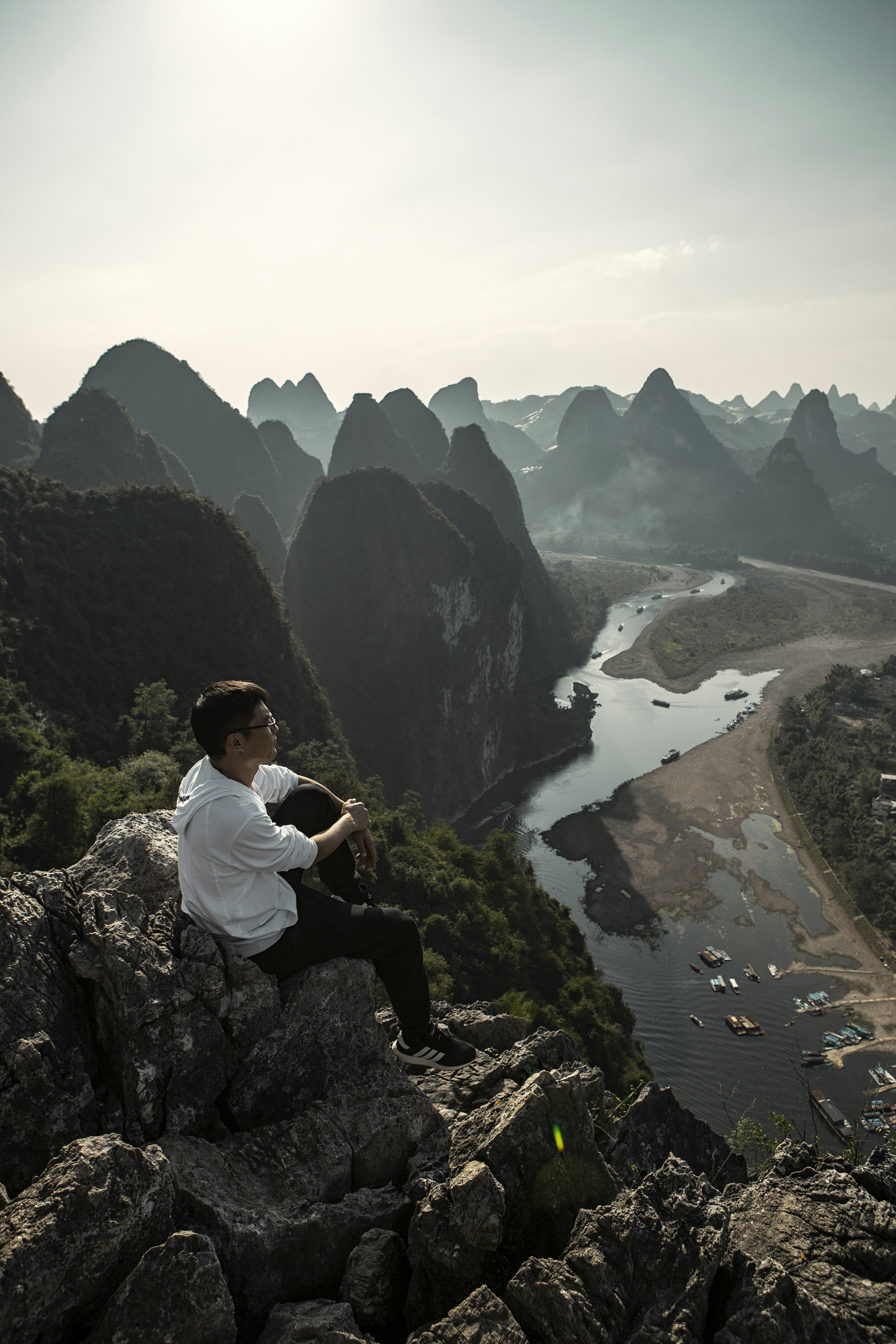 On the Edge of Quiet: A lone climber surveys a winding river among sculpted karst peaks