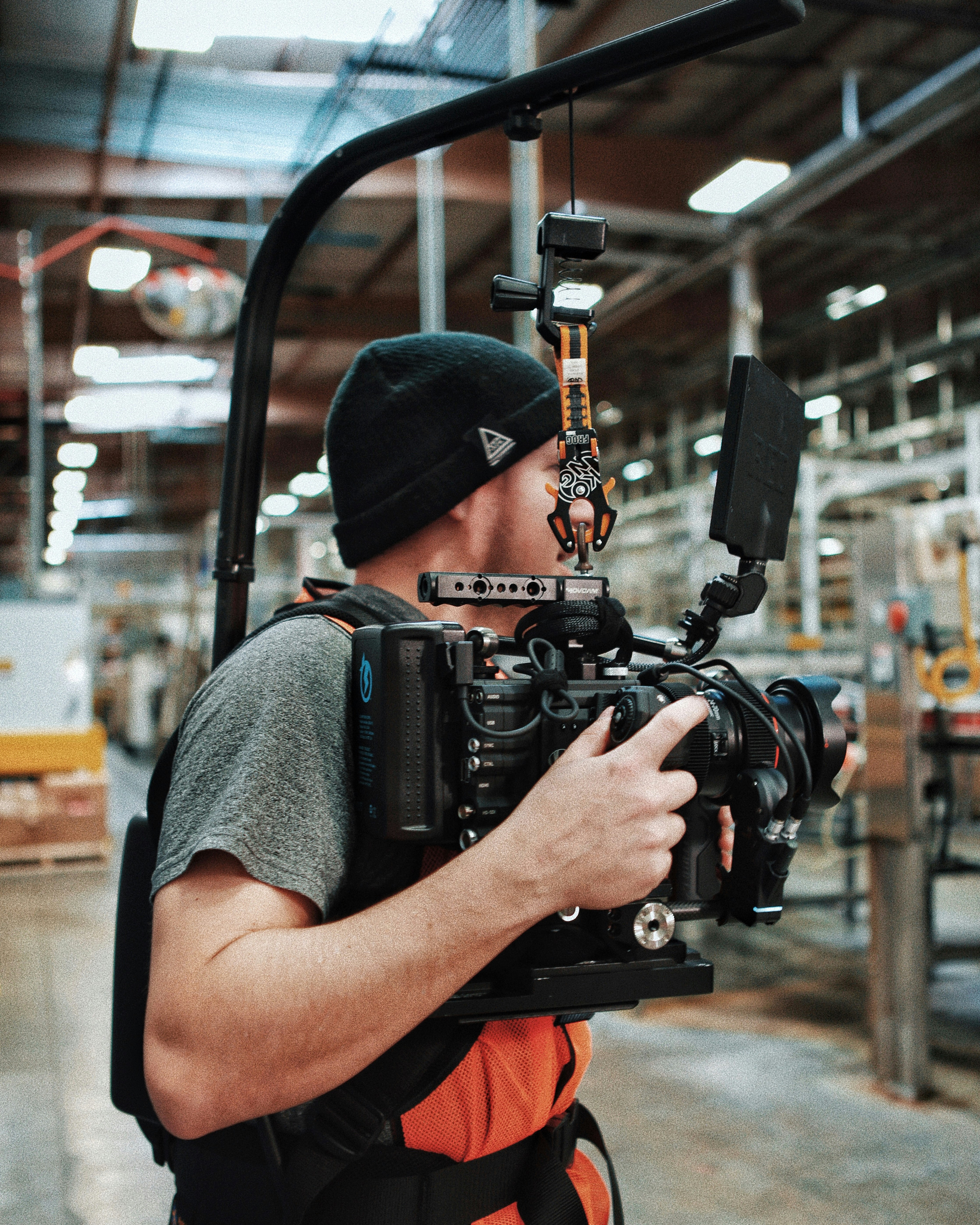 Man wearing gray shirt and gray bennies using black recorder camera ...