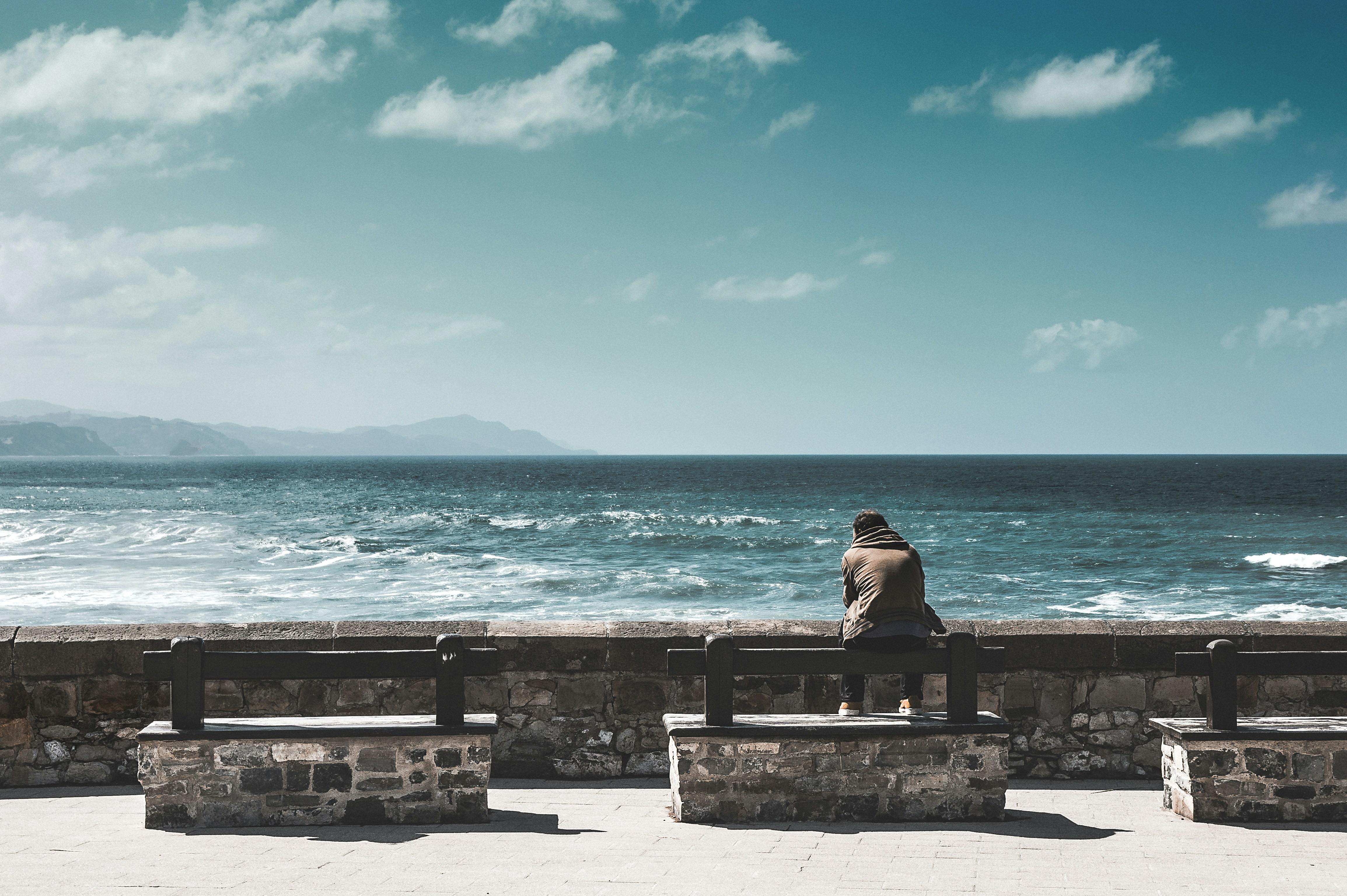 Man facing ocean under blue sky photo – Free Beach Image on Unsplash