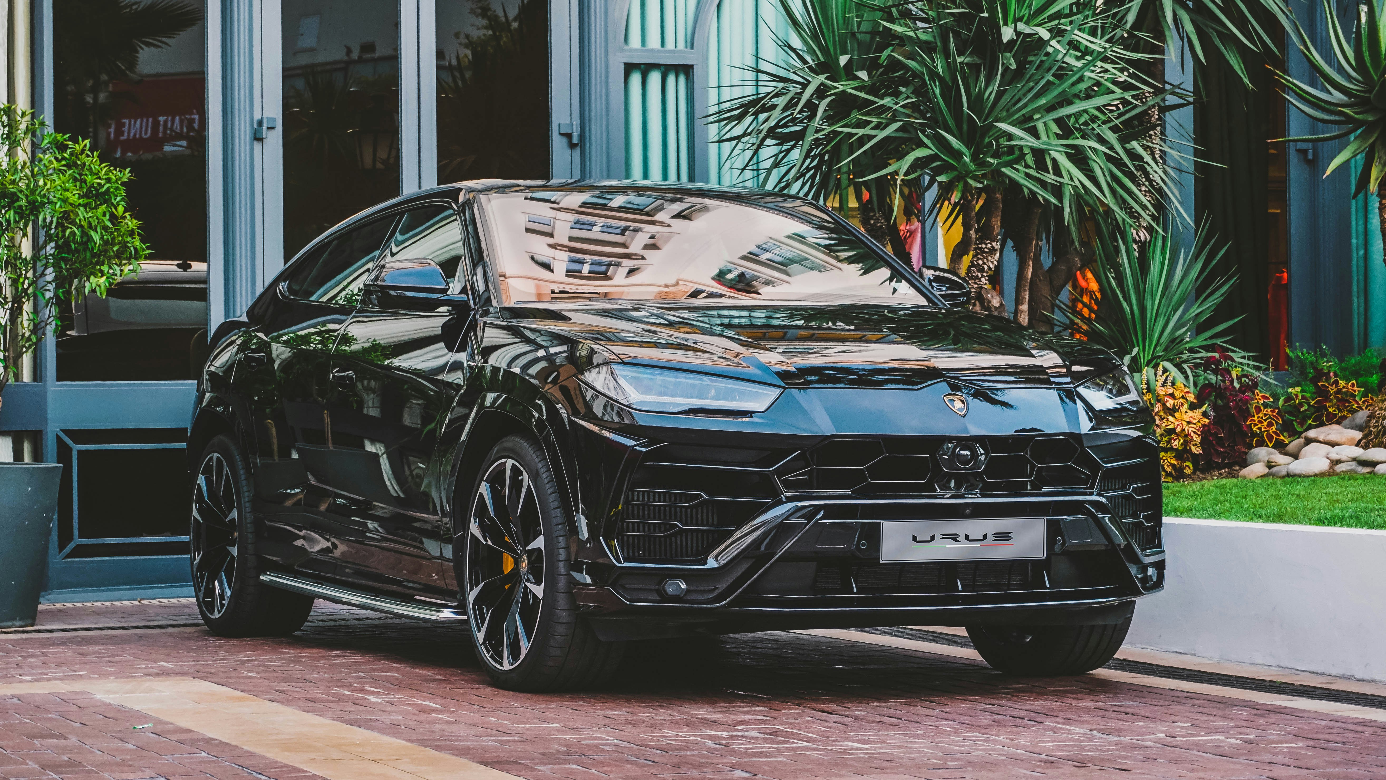 Lamborghini Urus | black car parked beside building and plants