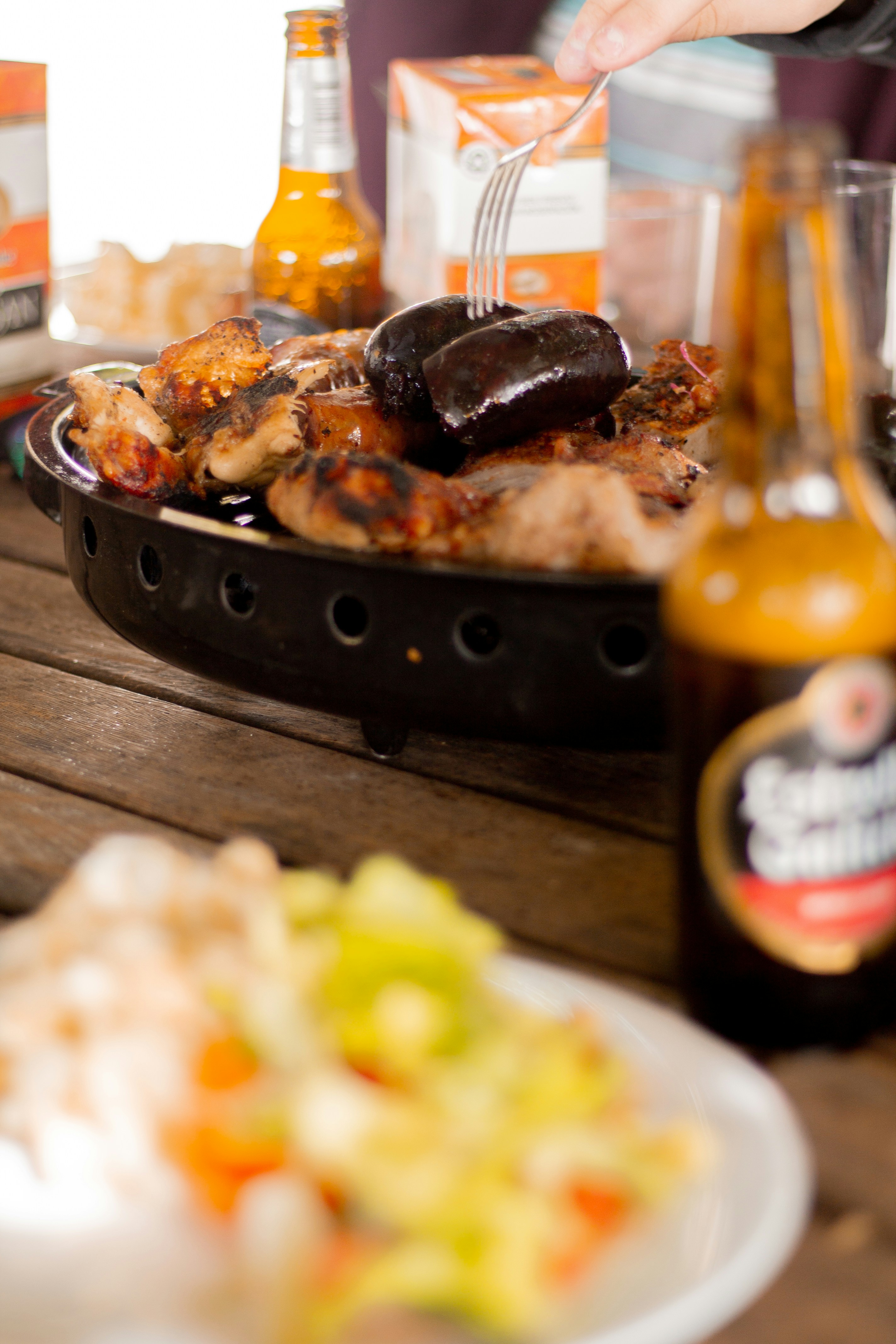 Charred Centerpiece: skillet of smoky bites on a sunlit wooden table