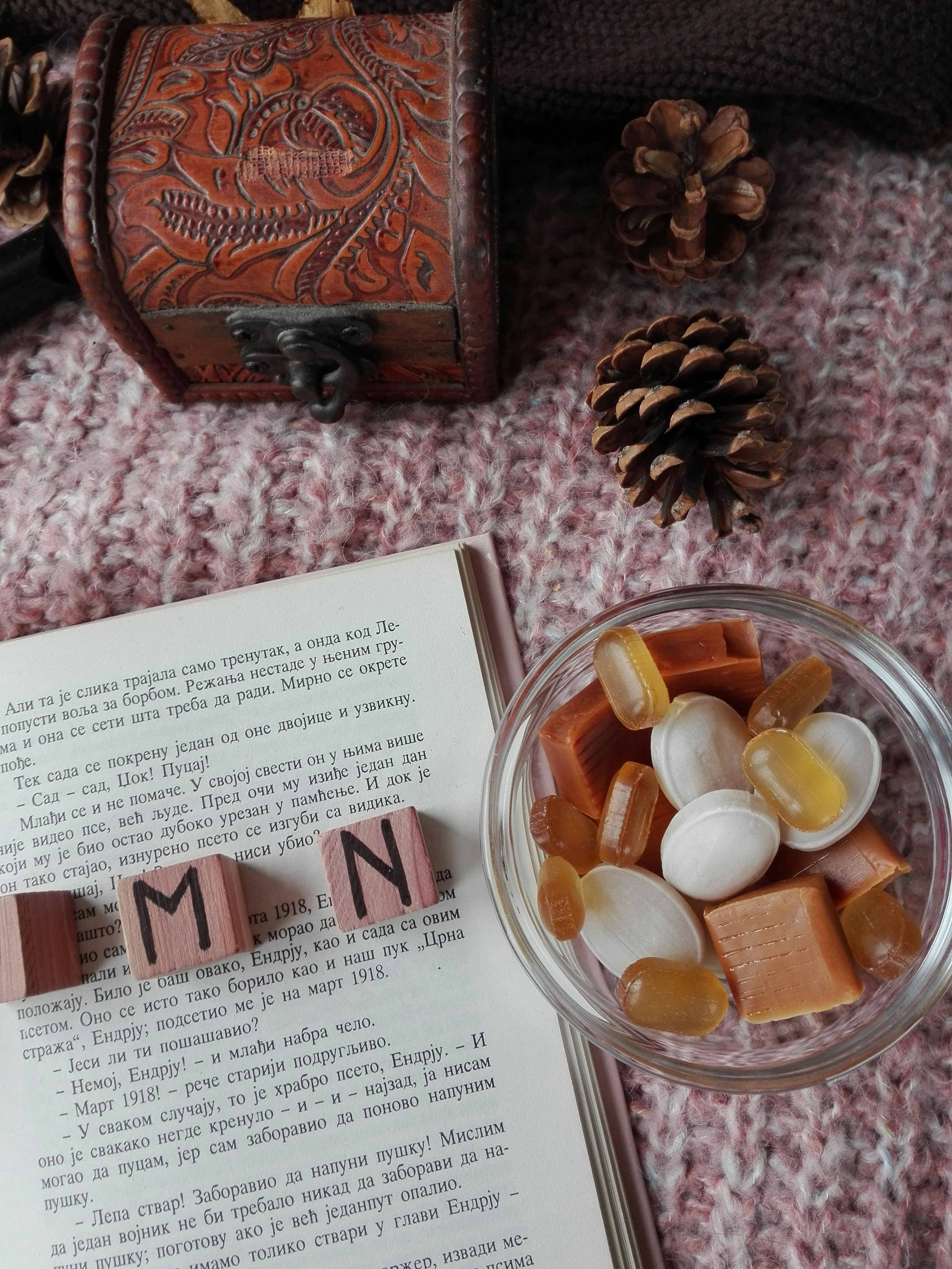 Pastel Knit Still-Life: Alphabet Tiles, Candy Bowl, and a Carved Chest