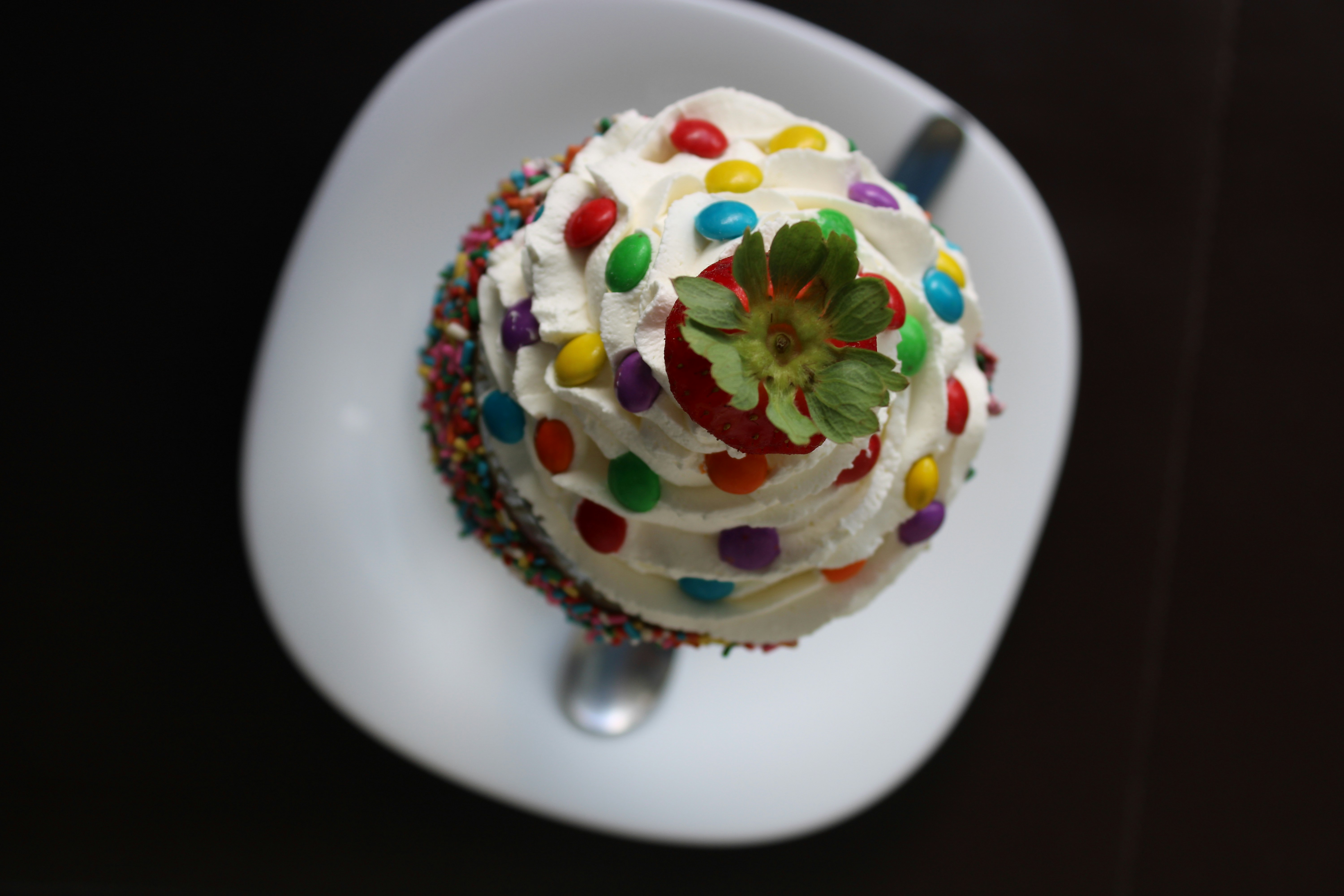 Candy Bead Crown: Top-Down Vanilla Cupcake on White Plate