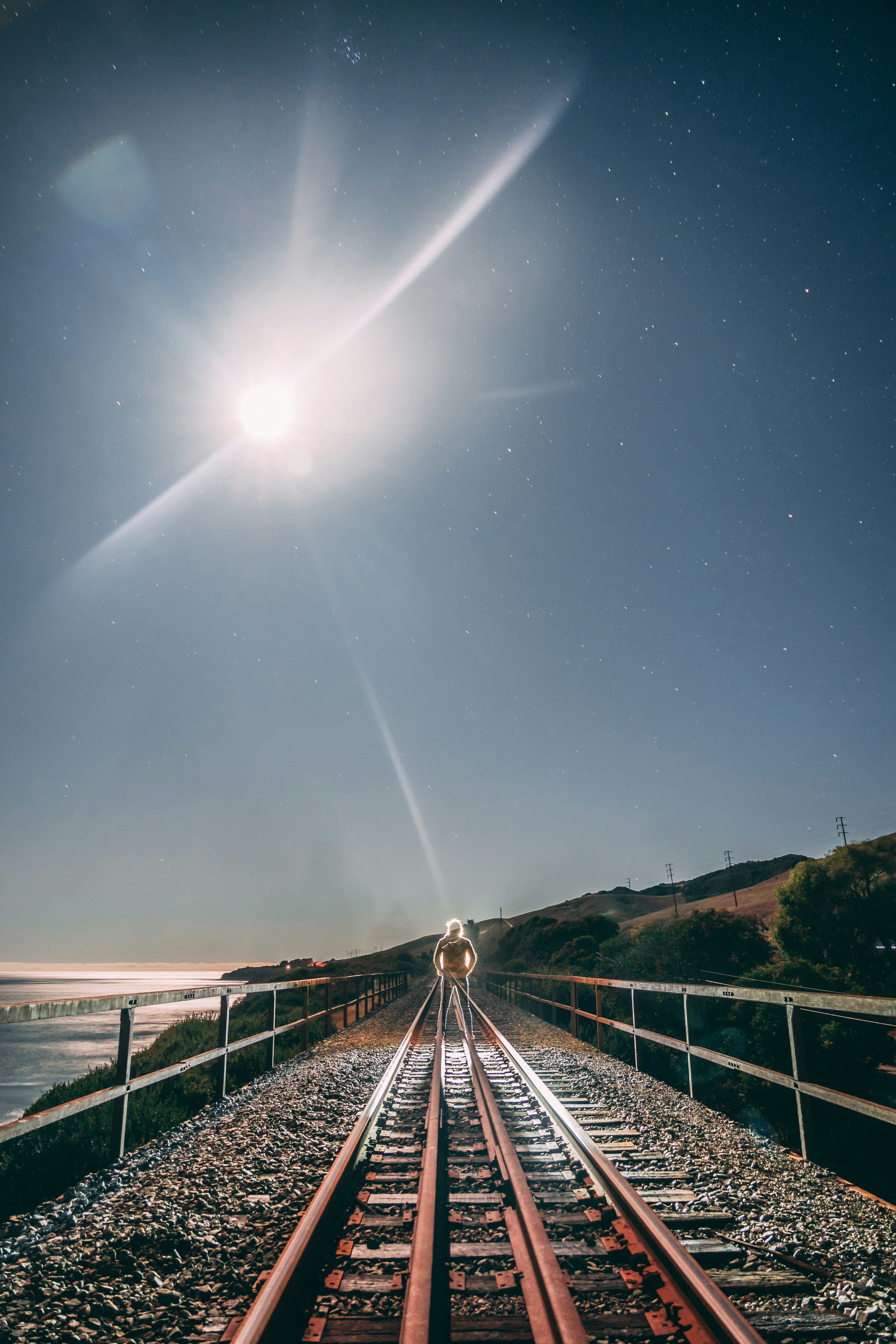Midnight Rails: A Lone Figure Under a Cosmic Burst