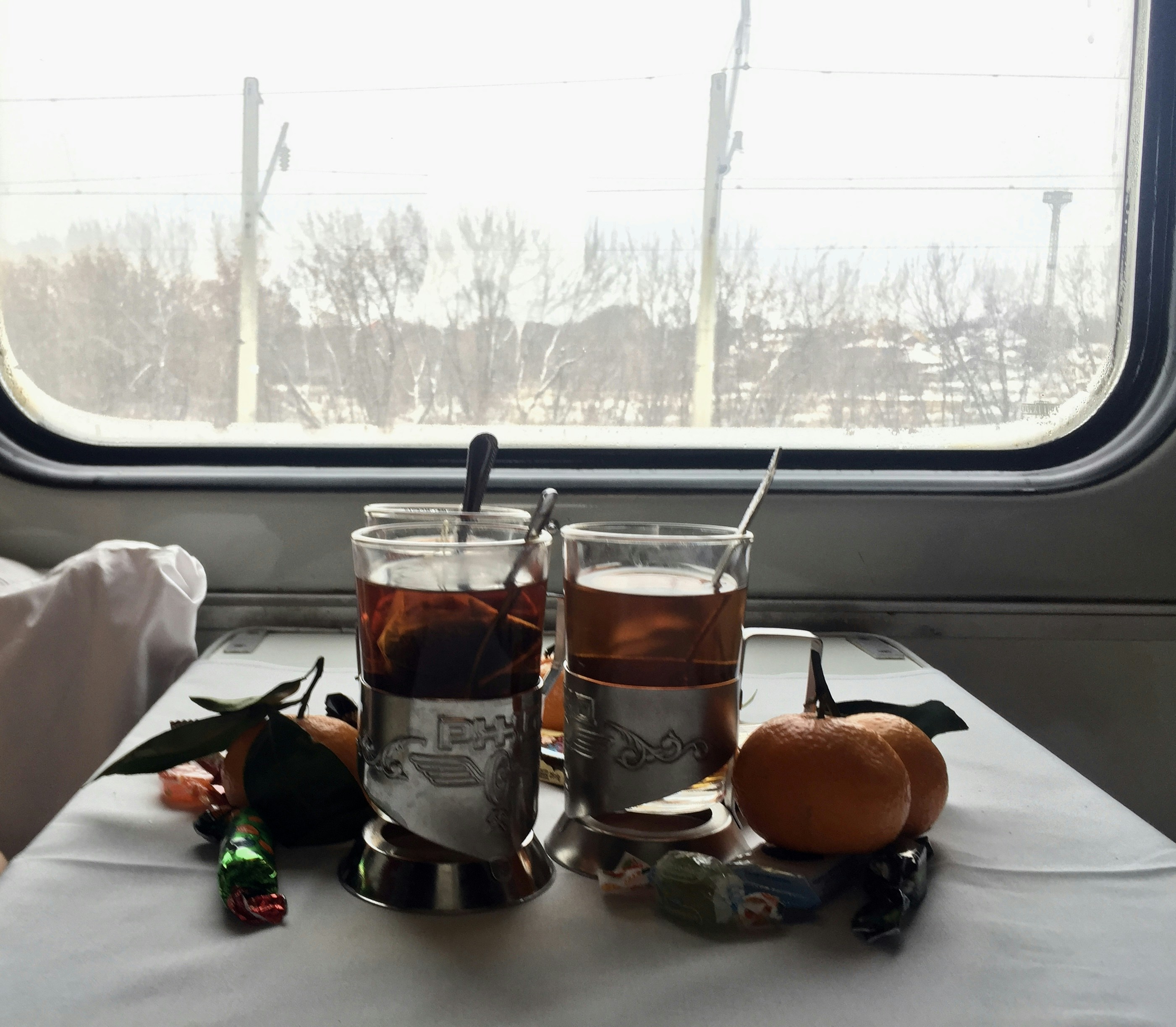 Two Glasses on a Snowlit Window Table: A Quiet Train Moment