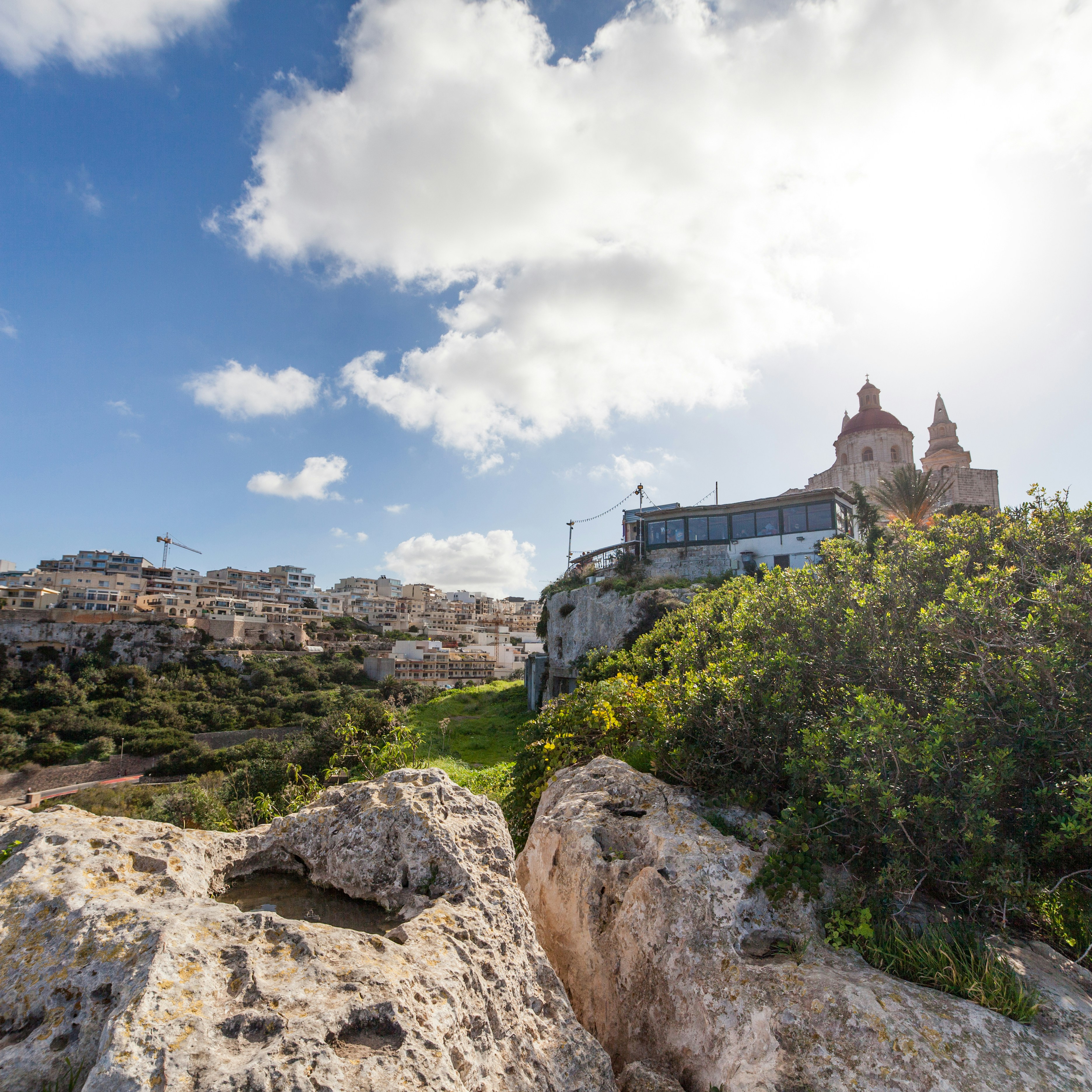 Cliffside Church Above a Rock-Strewn Terrace Under a Bright Sky