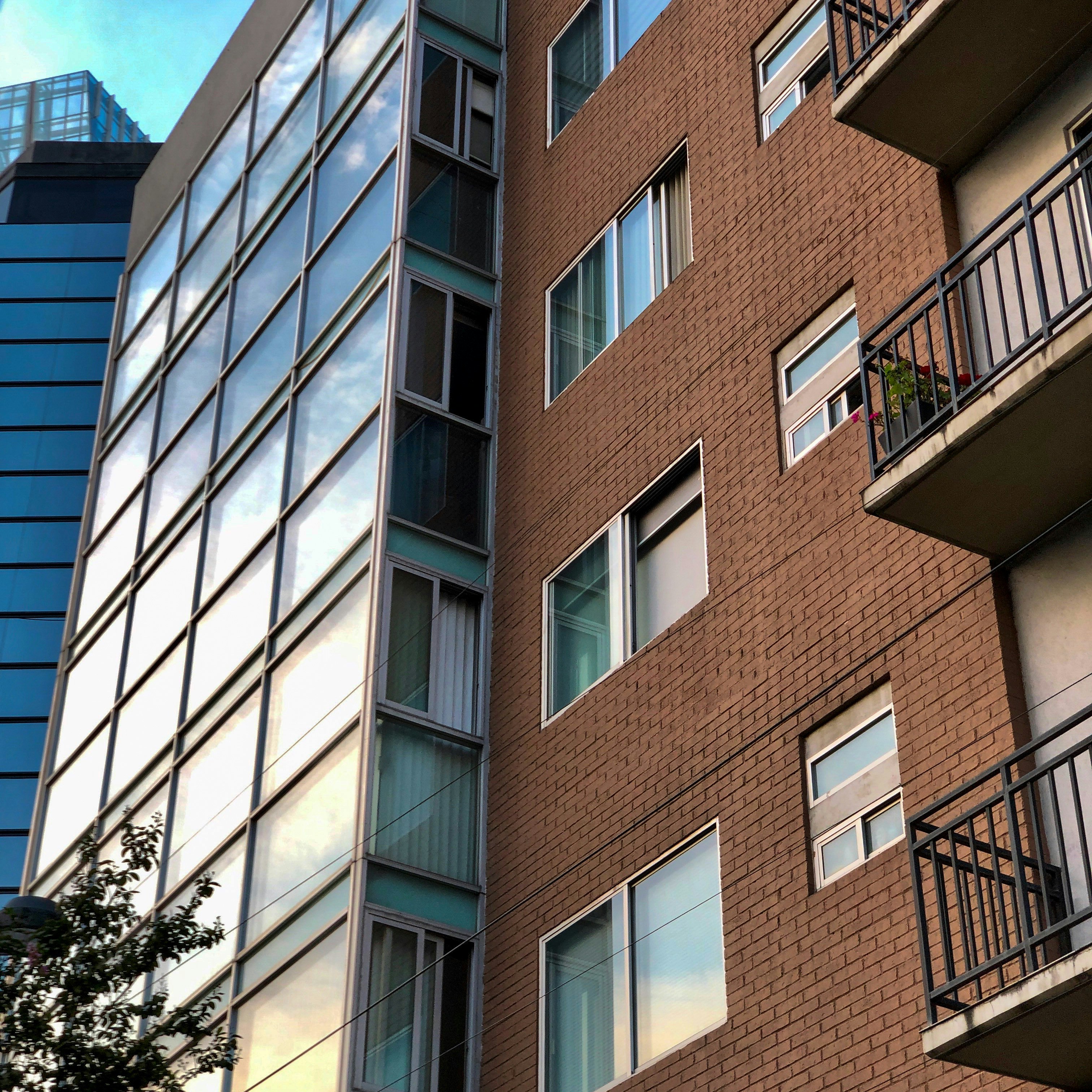 Quiet Geometry: Glass Facade Intersecting Brick Tower