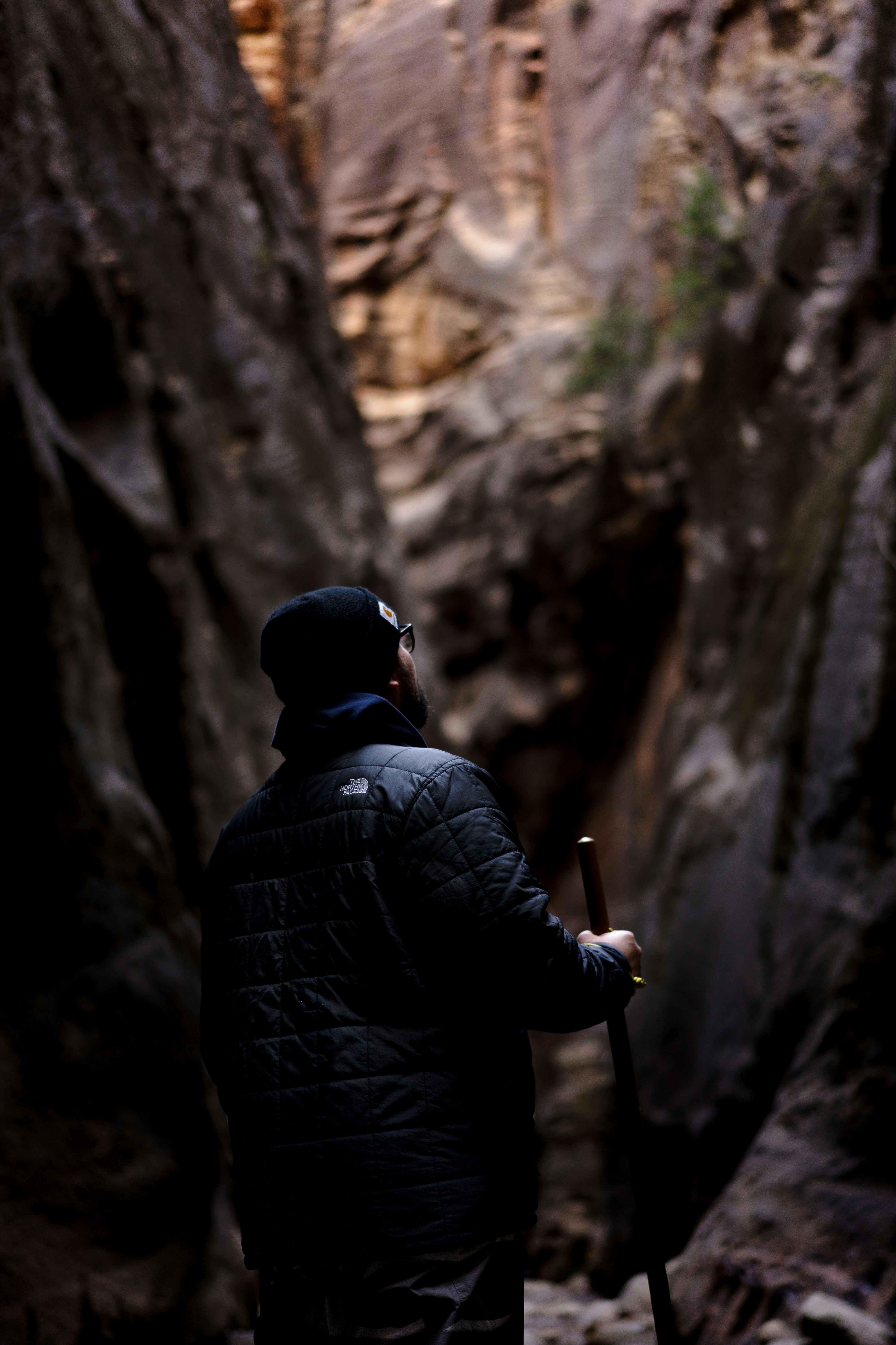 Lone Figure Anchored in a Shadowed Canyon Corridor