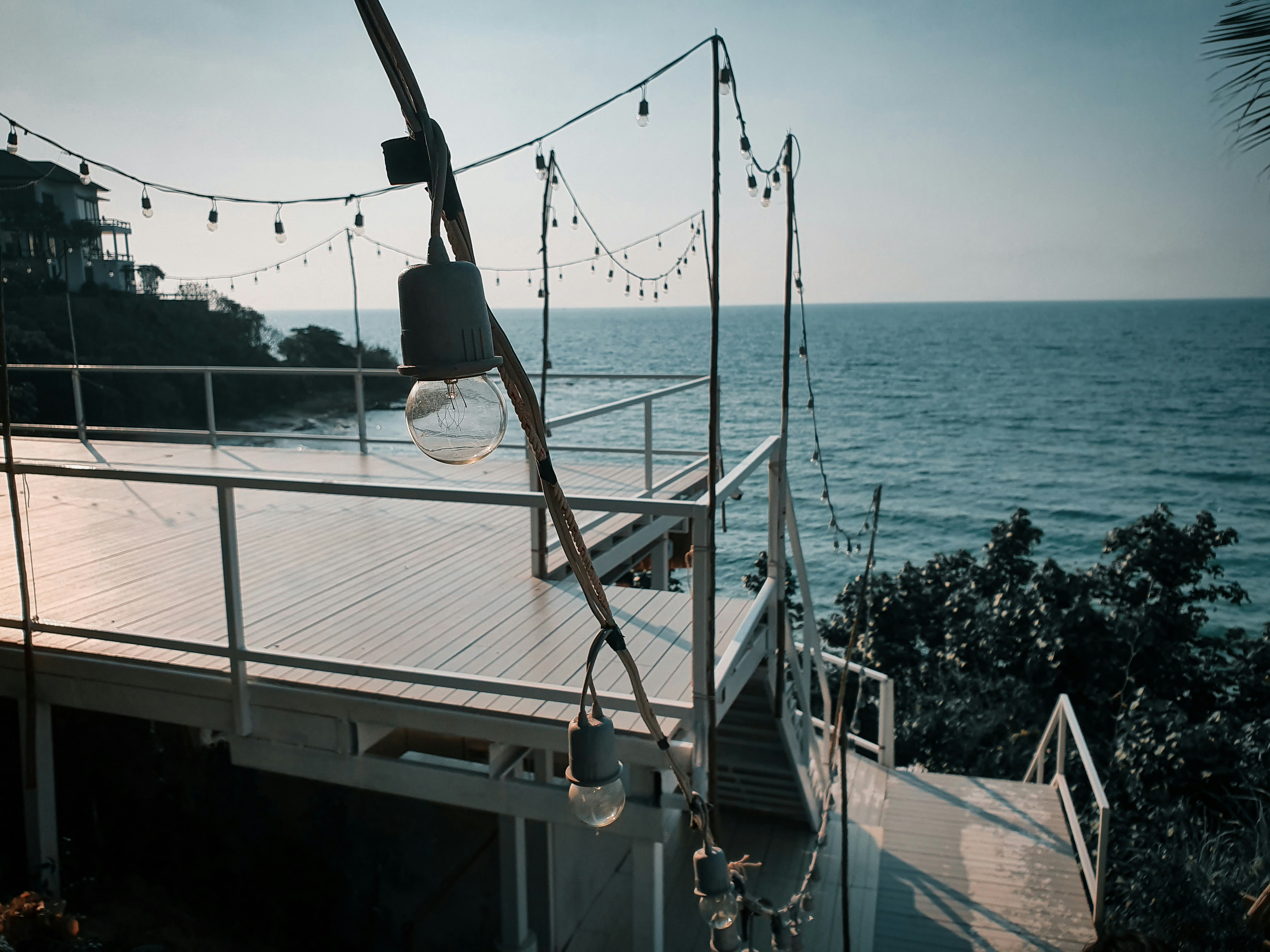 Lantern Bokeh on a Seaside Deck: String Lights Framing the Open Ocean