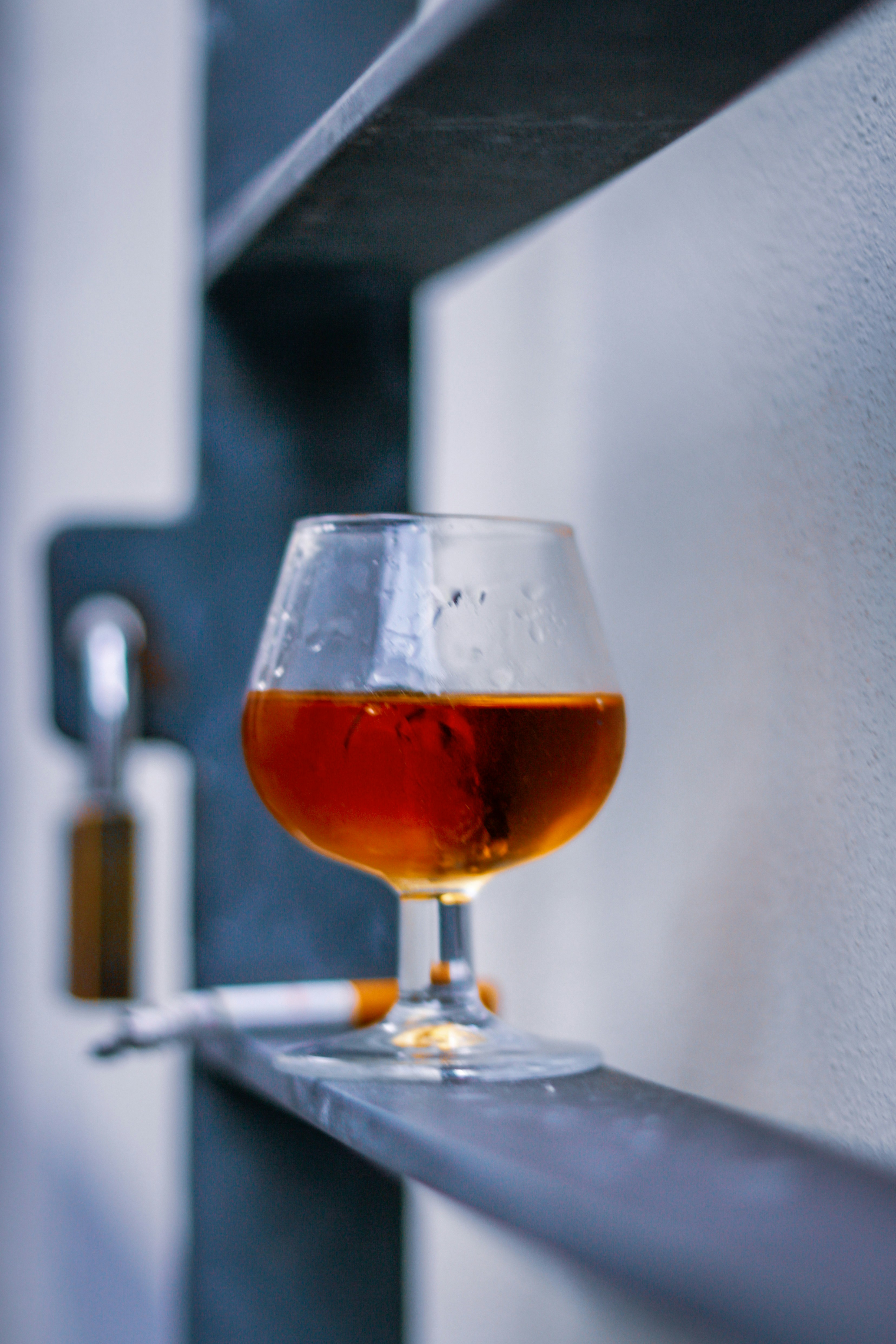Amber on the Rail: a stemmed glass framed by steel and blue dusk