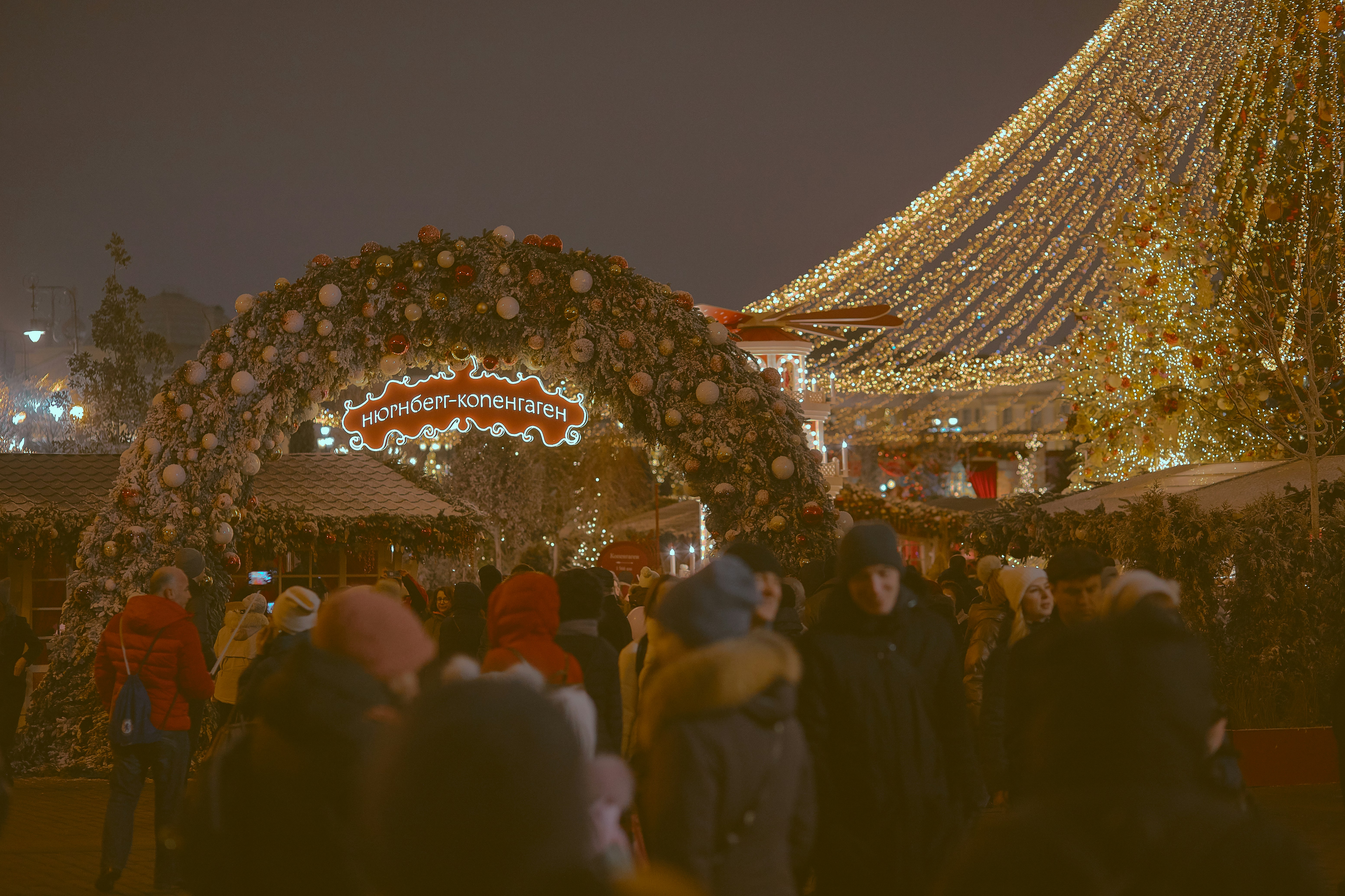 Floral Arch Under a Web of Lights Illuminates a Night Market