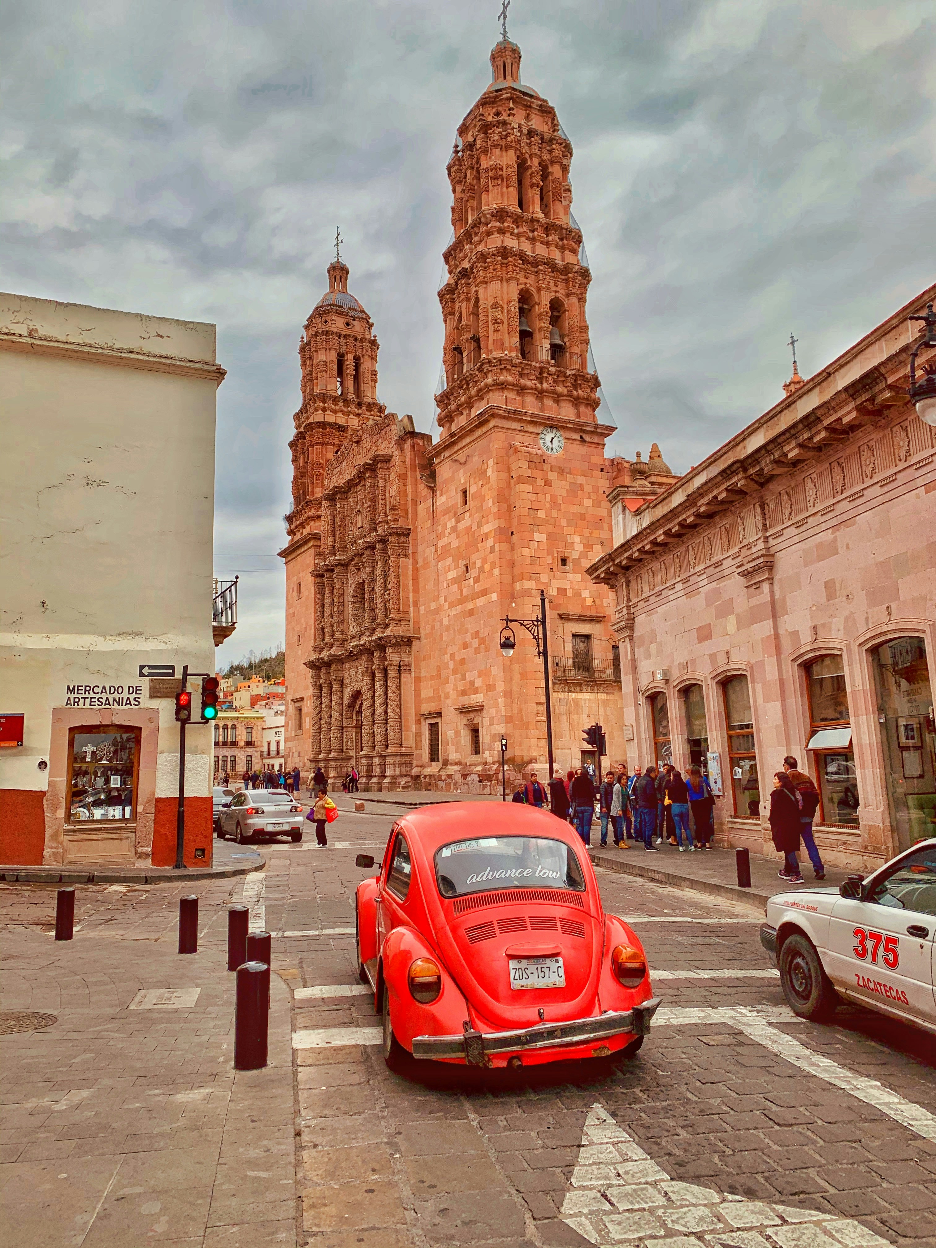 Red Beetle Beneath Twin Baroque Towers in a Cobbled Plaza