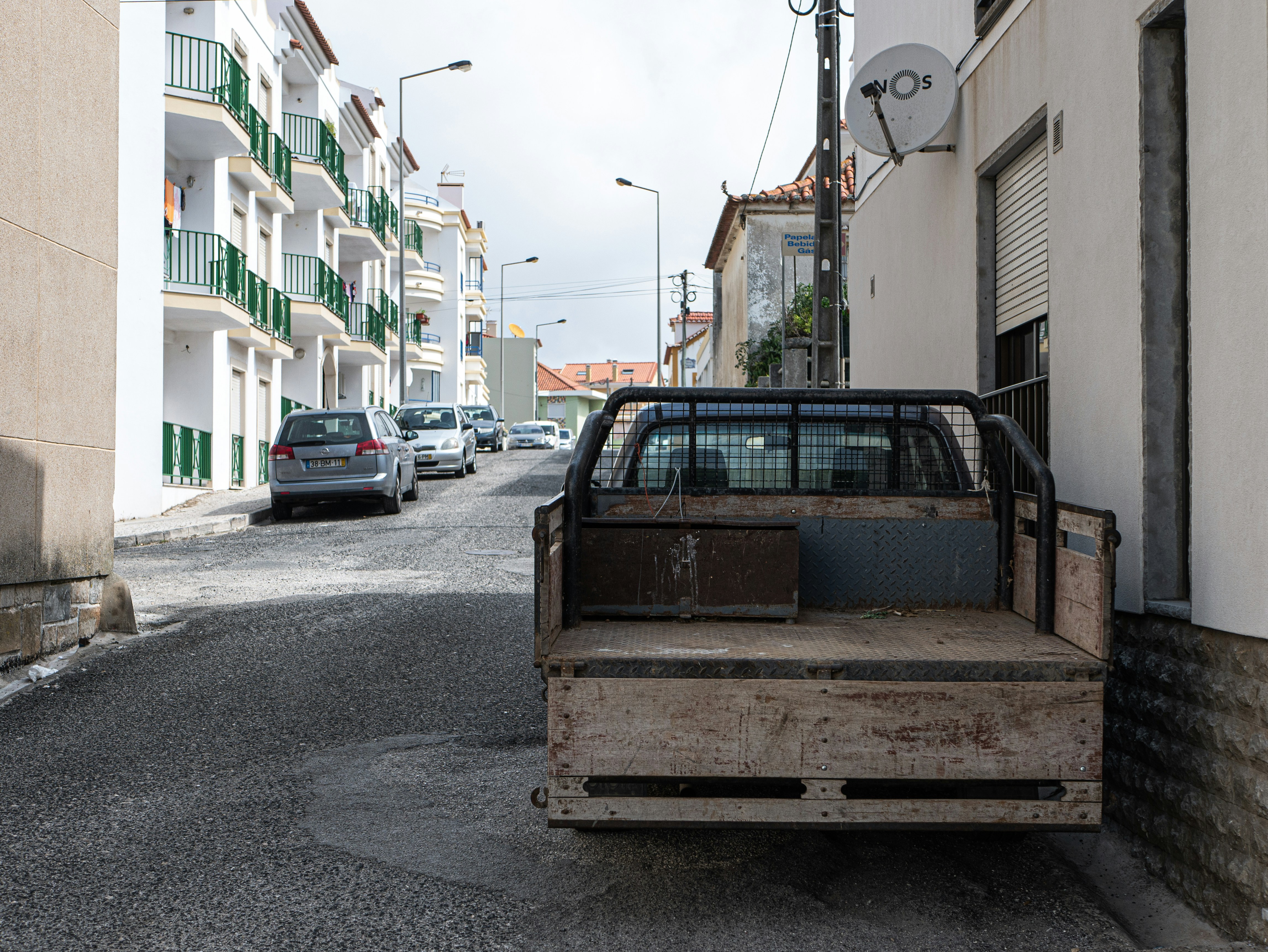 Rusted Bed, Quiet Avenue: A Sunlit European Street