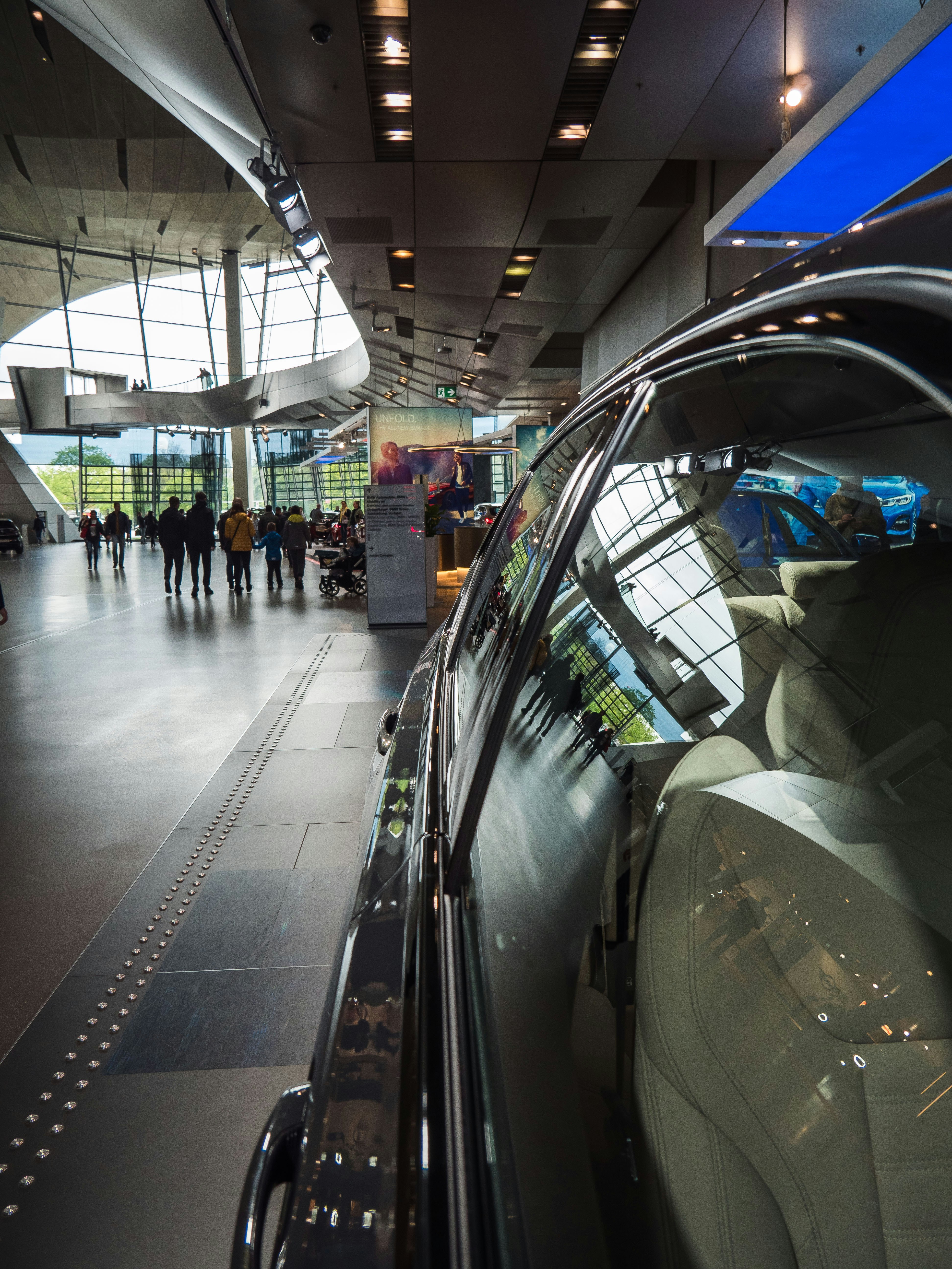 Reflections in the Atrium: A Side Glance at a Sleek Showroom Car