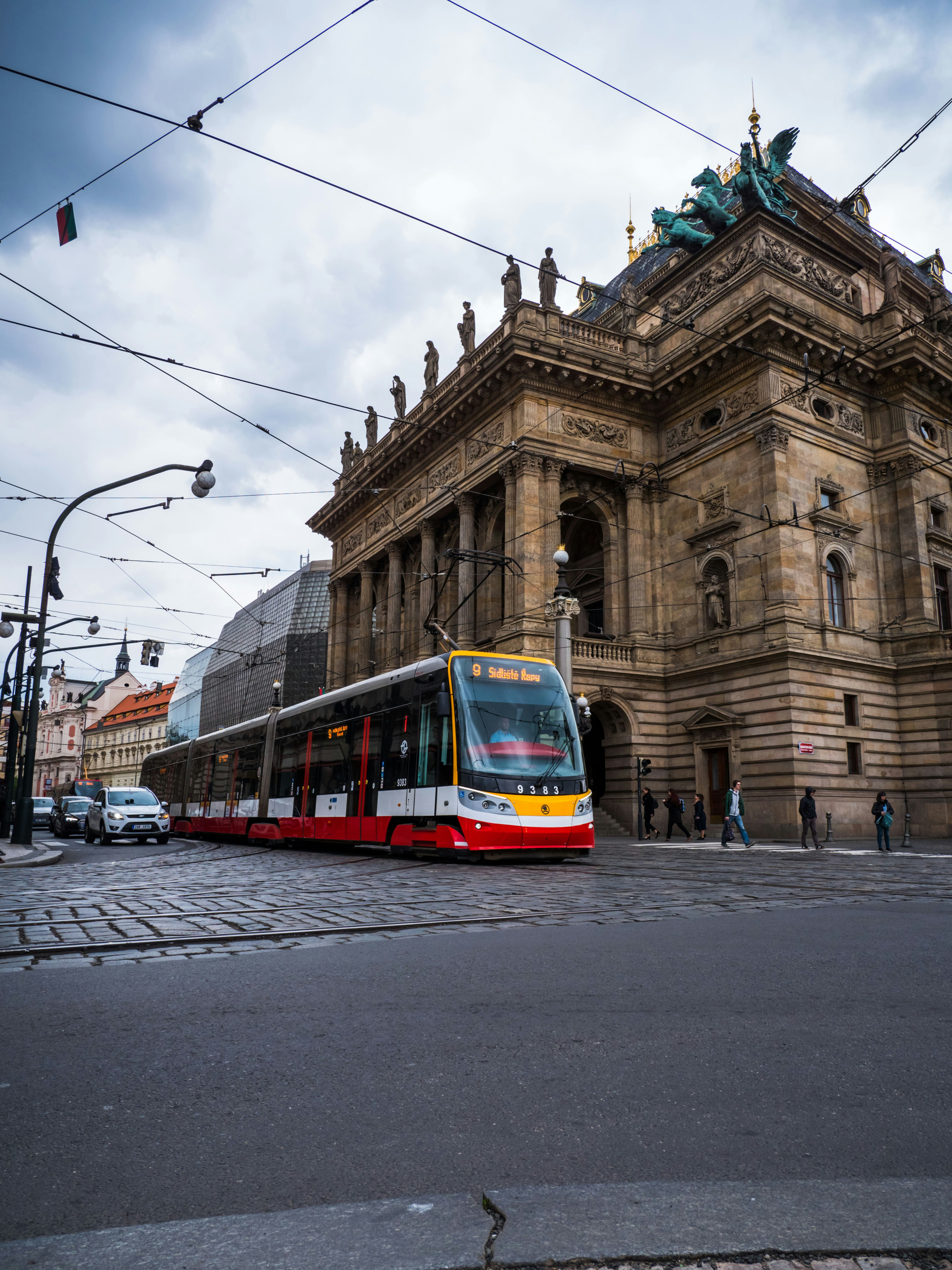 Arrêt de bus rouge et blanc à côté d’un bâtiment en béton brun pendant ...