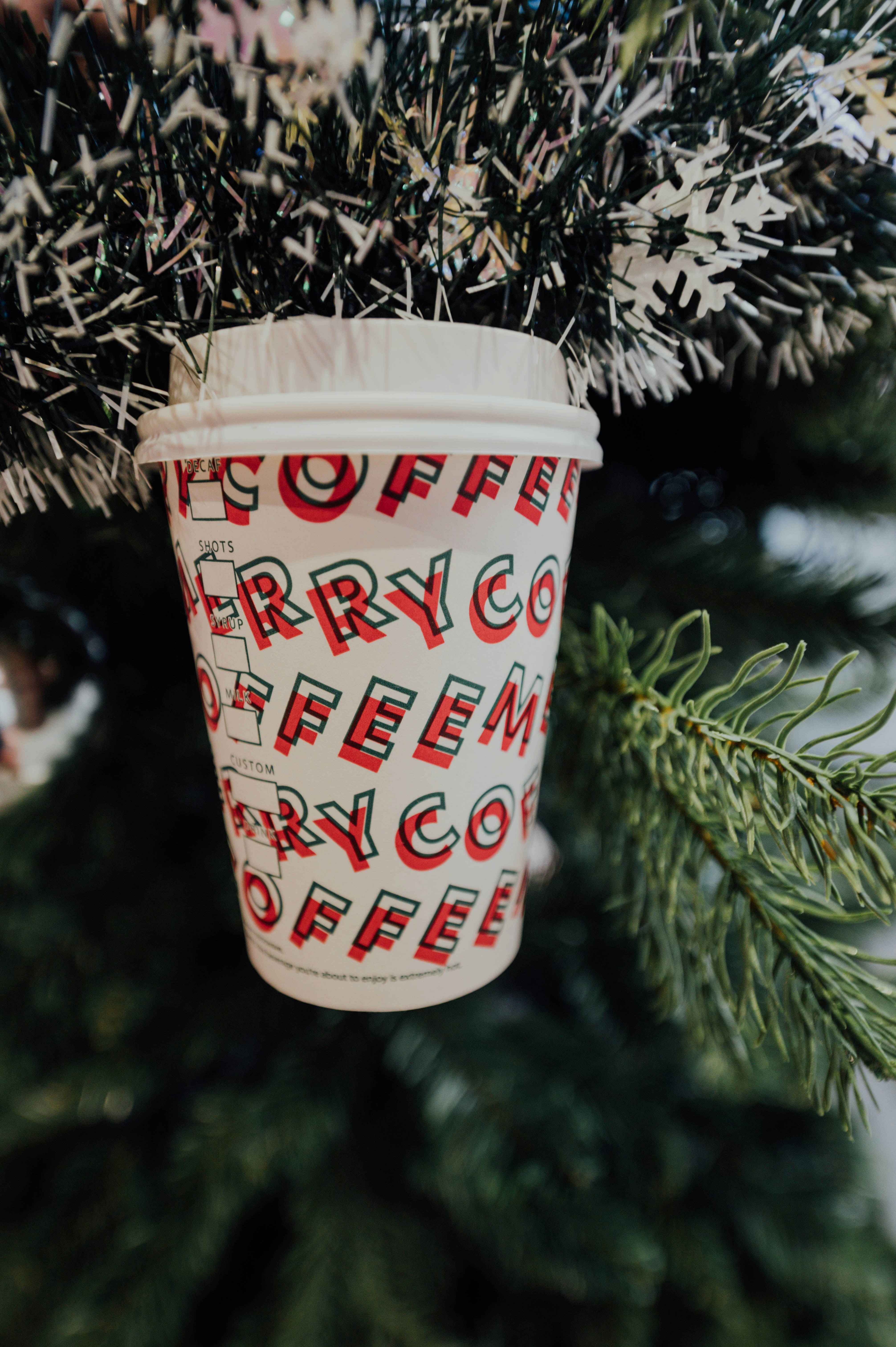 Tinsel-Threaded Coffee Cup Amid a Christmas Tree