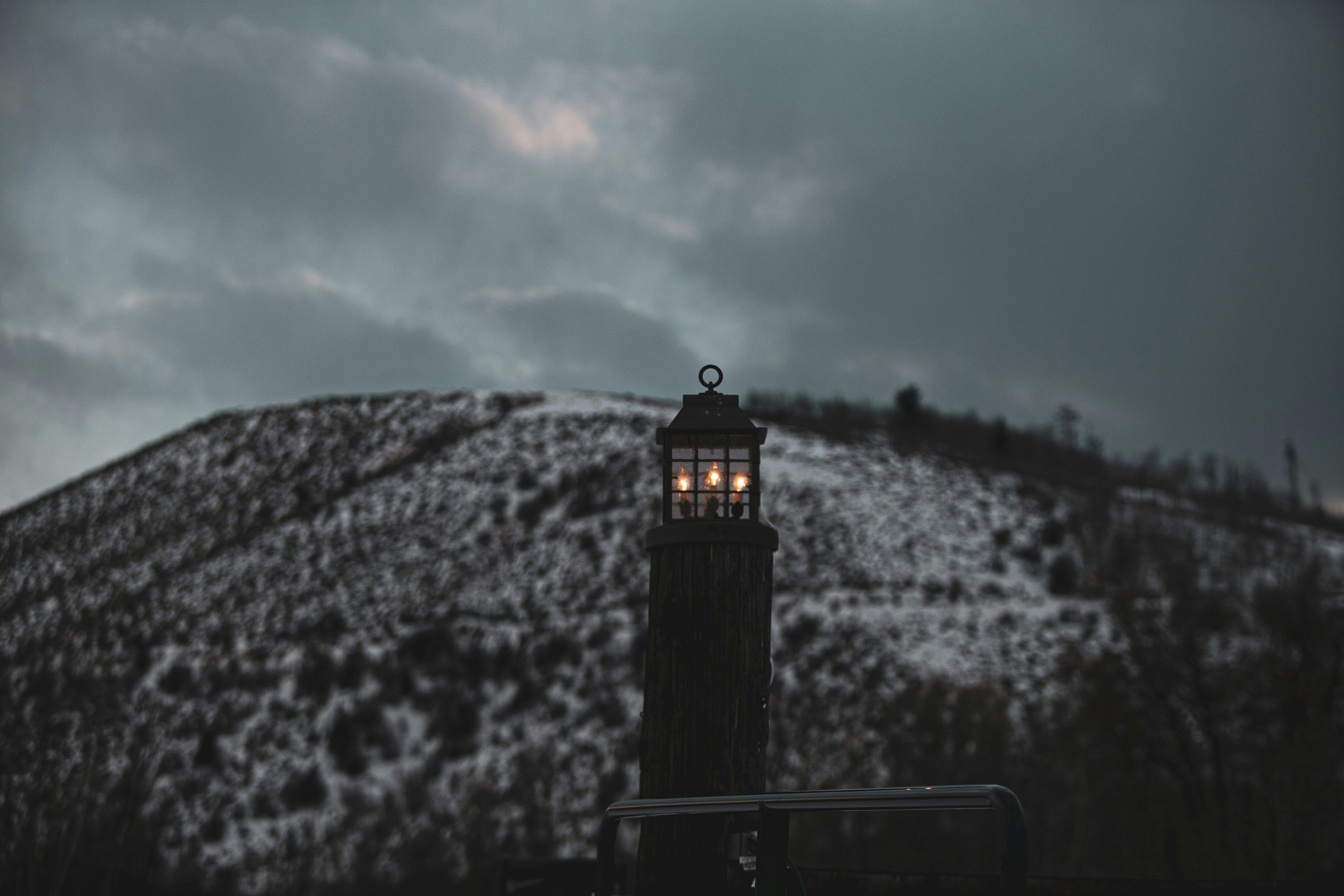 Lone Lantern on a Snow-kissed Ridge