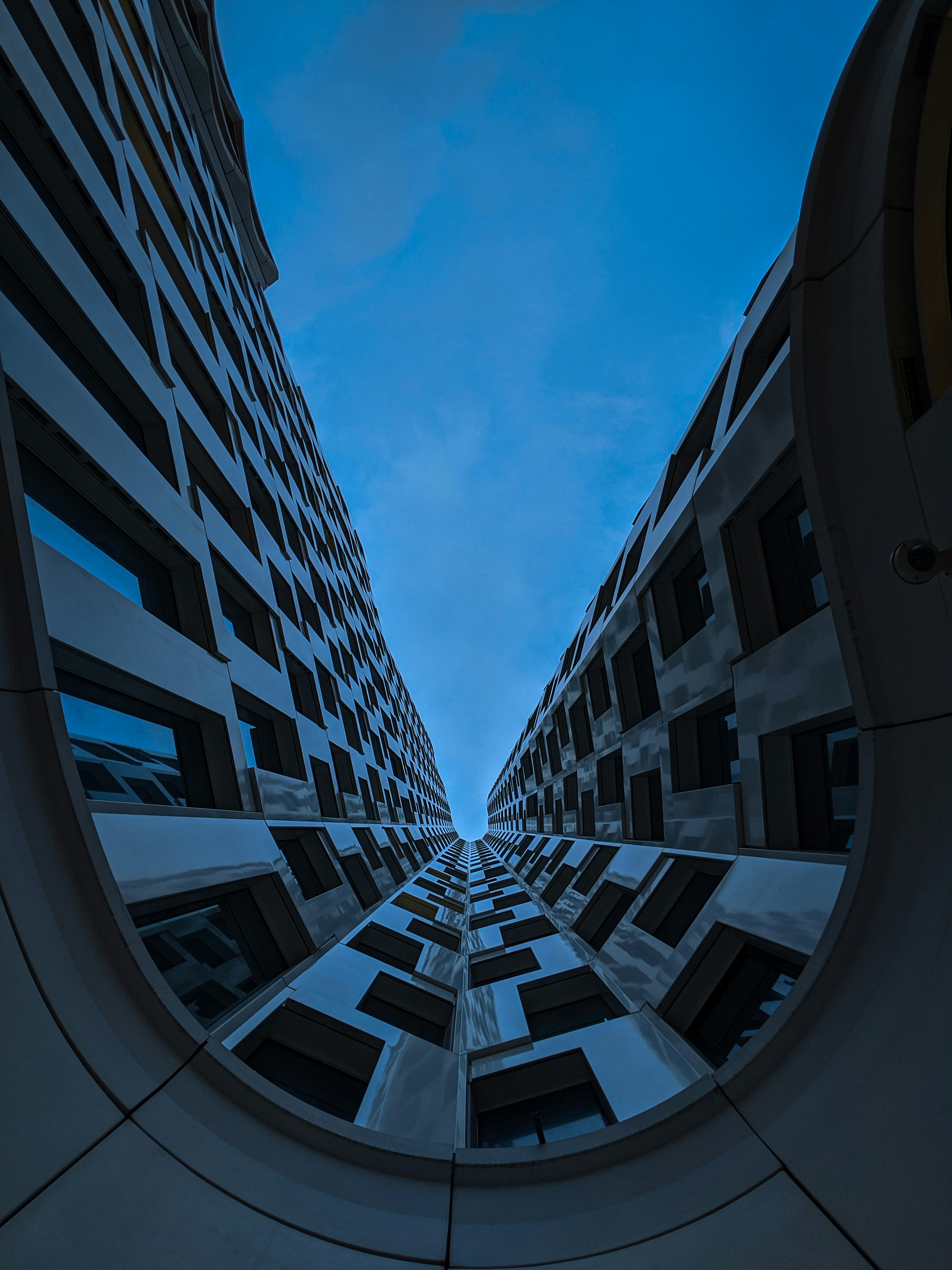 A view of a building through a circular window photo – Free Blue Image ...