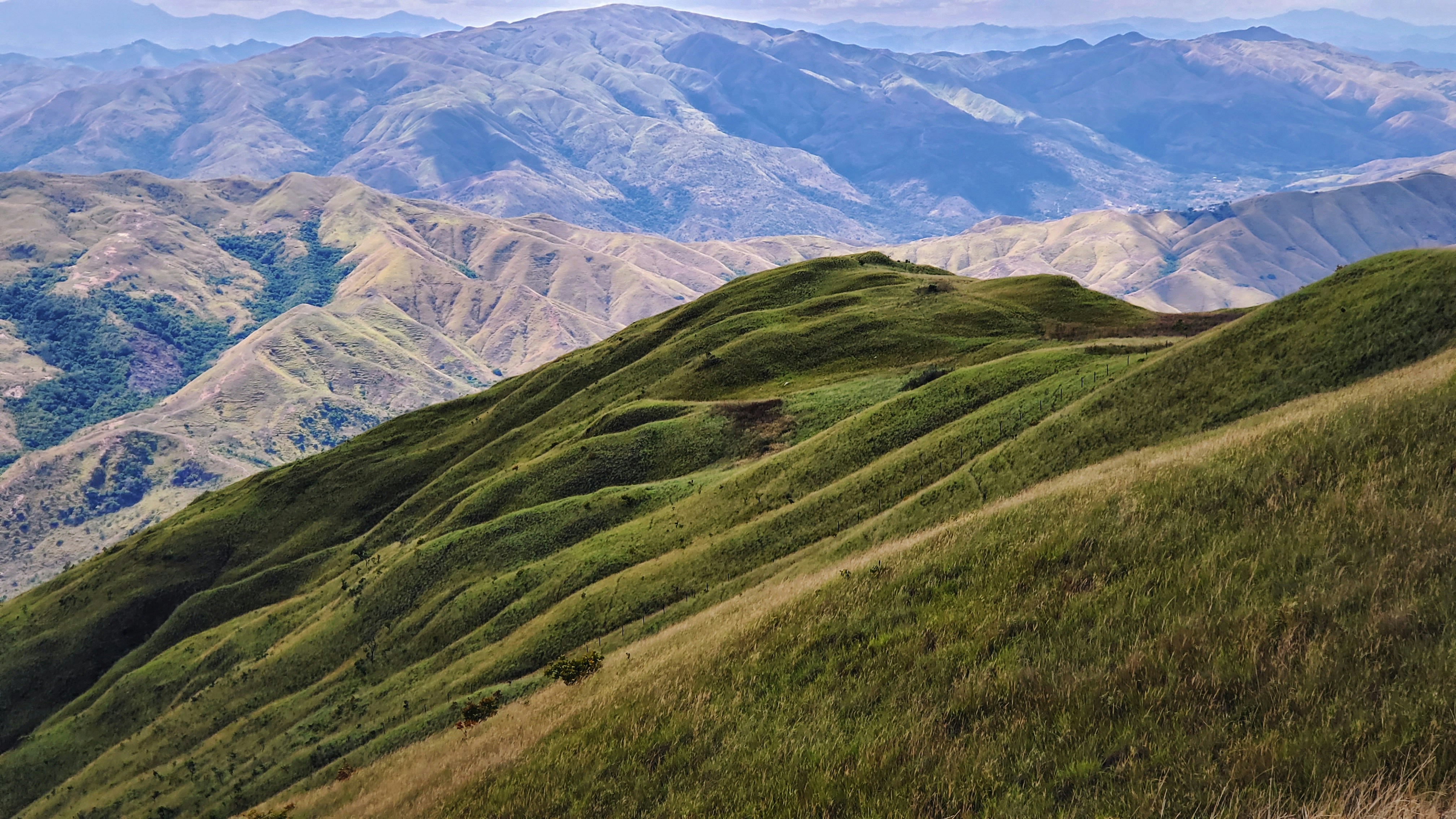 Emerald Crest Over Rolling Hills Toward a Blue Mountain Horizon