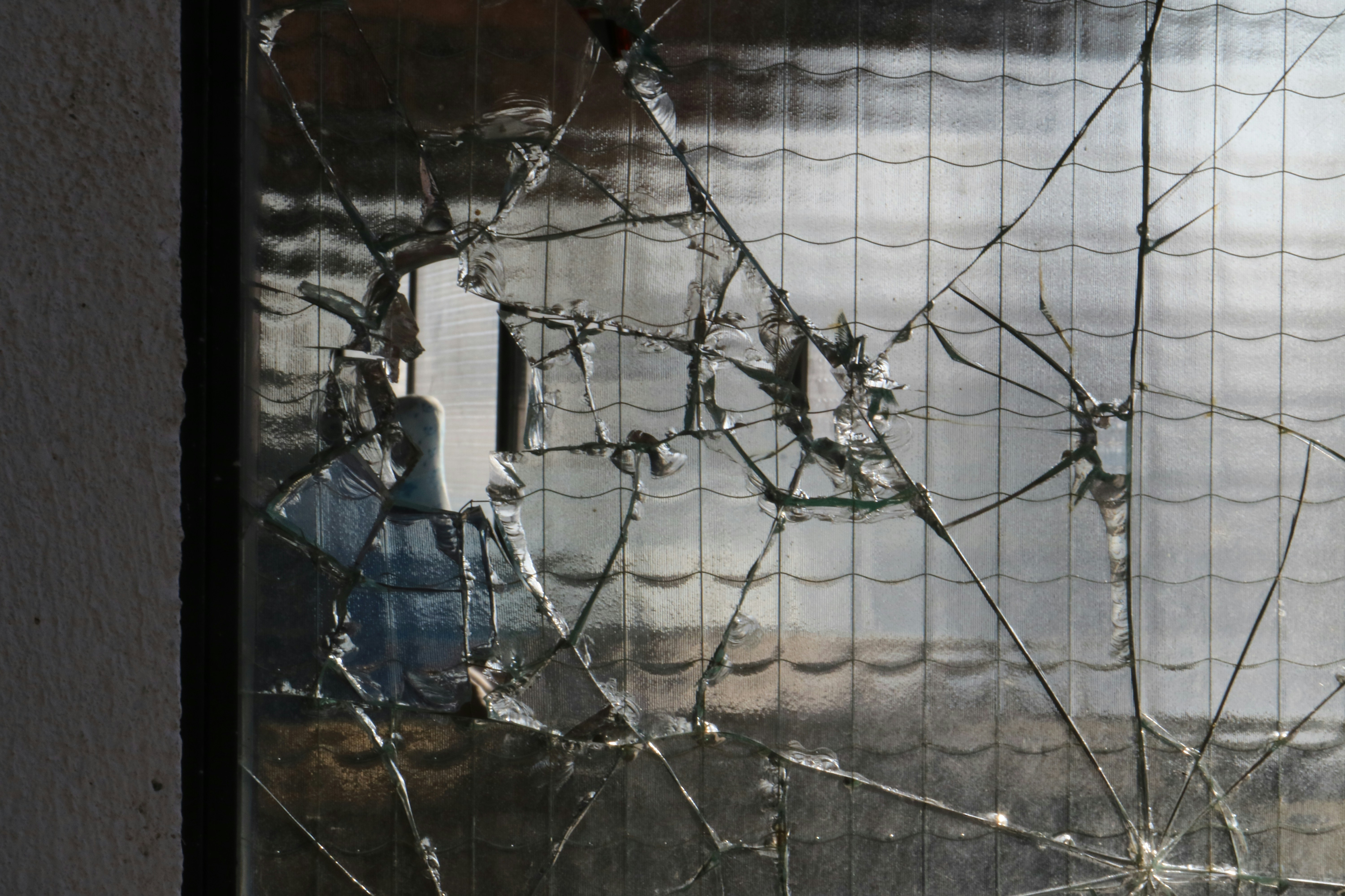 A broken window with a blue fire hydrant behind it photo – Free Grey ...