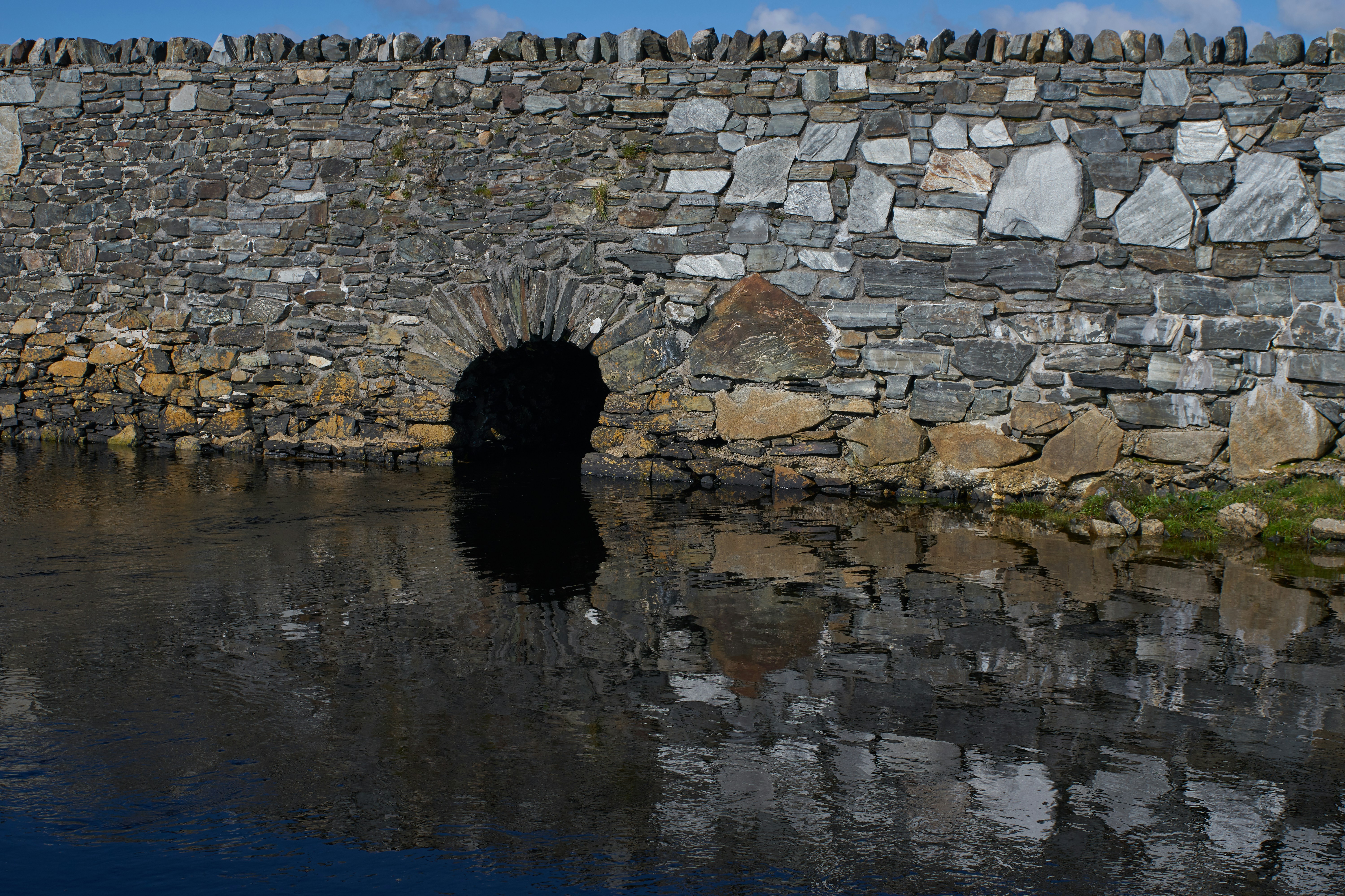Stone Arch Echoes: A Granite Seawall and Its Quiet Mirror