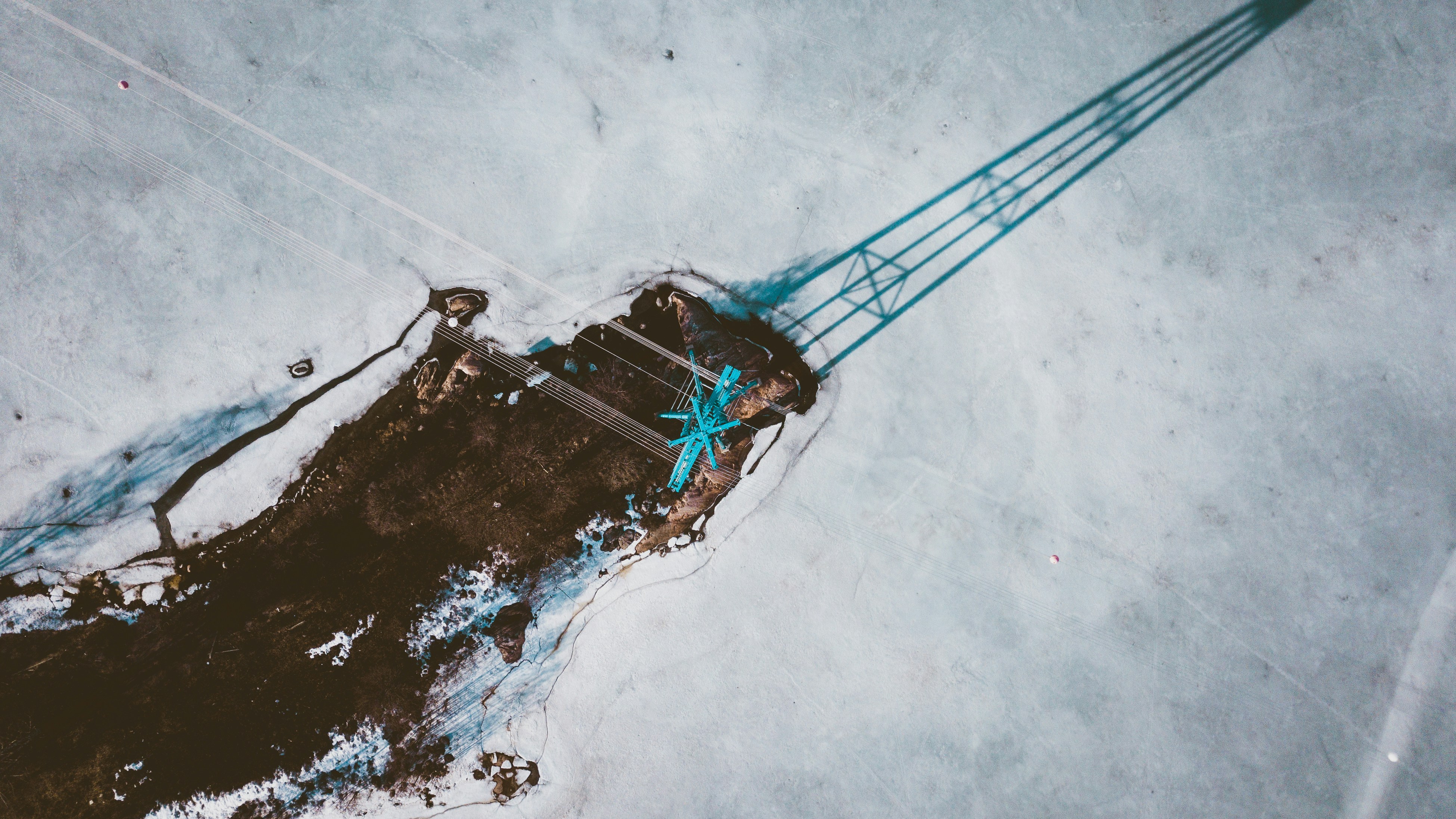 Blue Lattice Beacon Over Snow: A Drone View of Frozen Transmission Tower