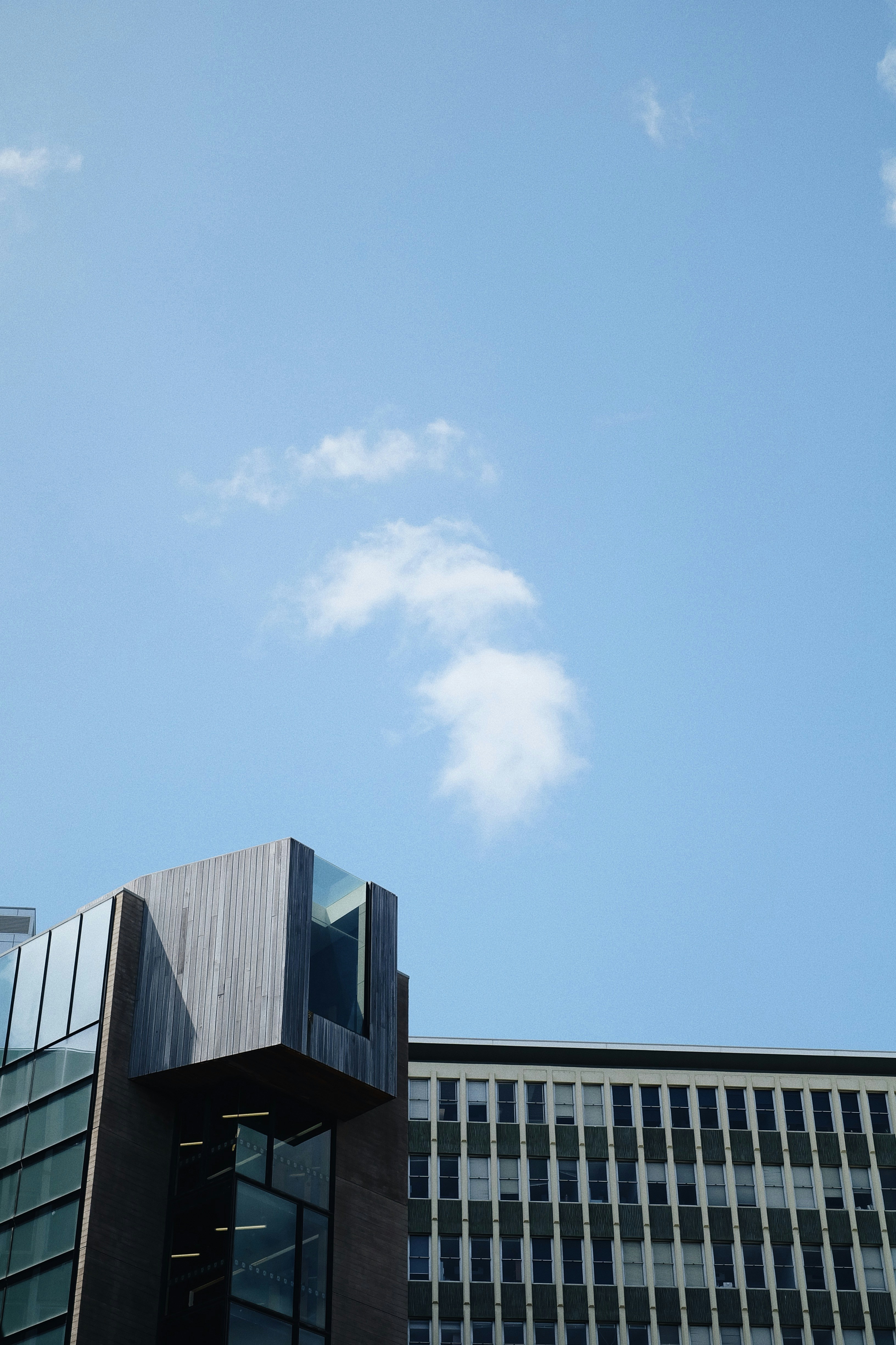 Modern building facade with angular designs set against a clear blue sky.