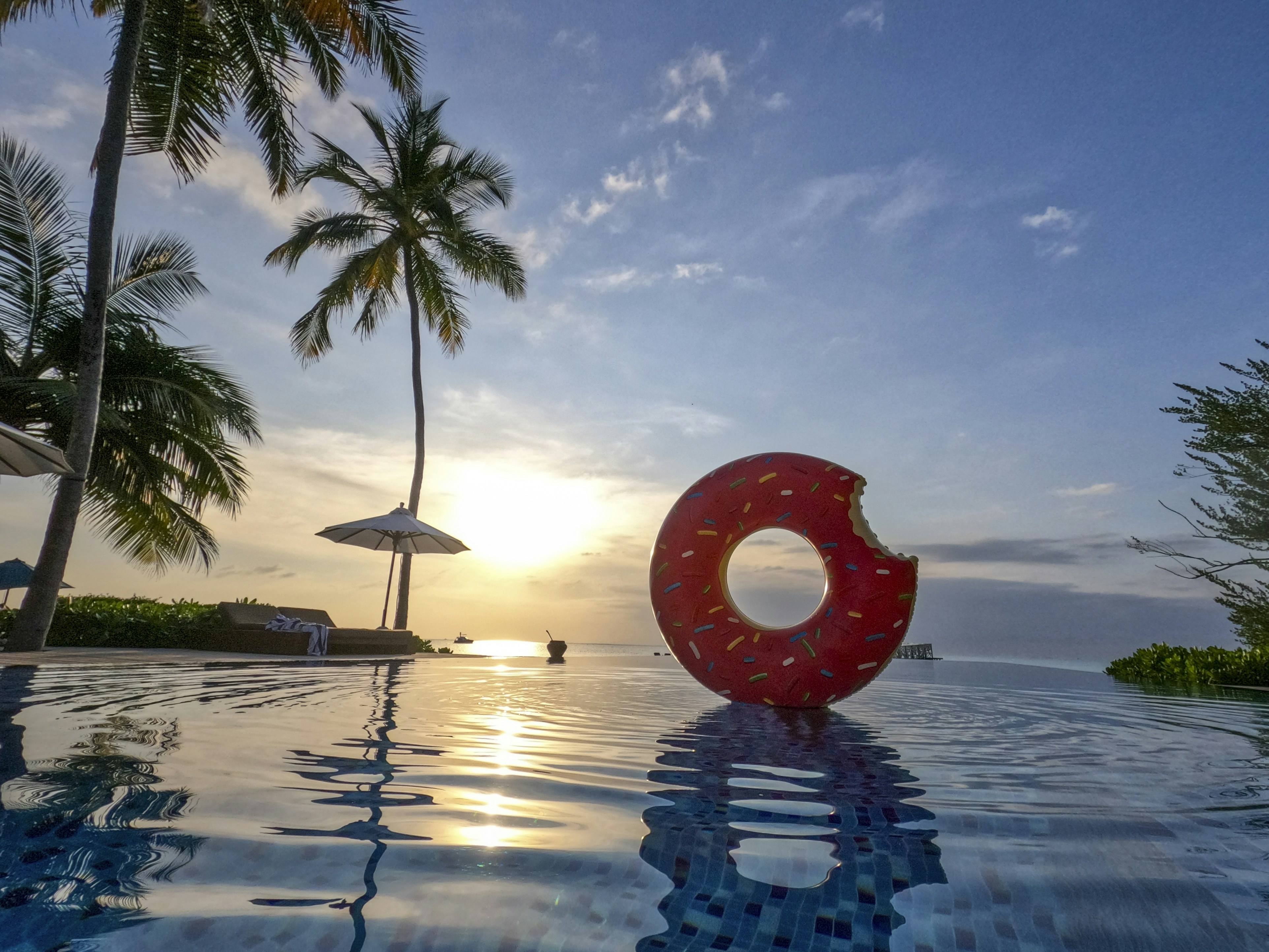 Donut float at beautiful pool during sunset at Maldives Fairmont | doughnut floater on pool