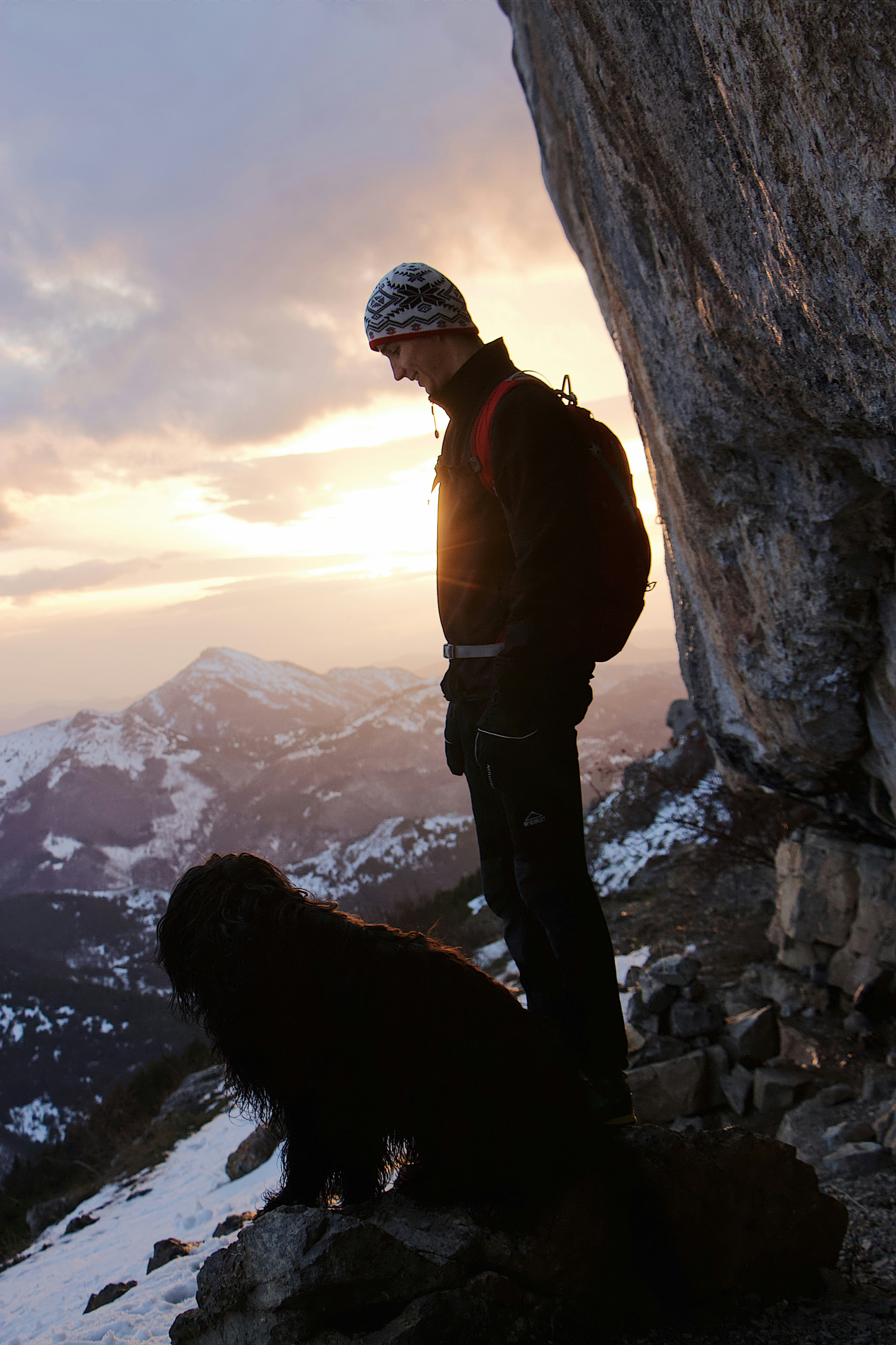Sunset Sentinel on a Snowy Ridge: Climber and Dog at the Edge
