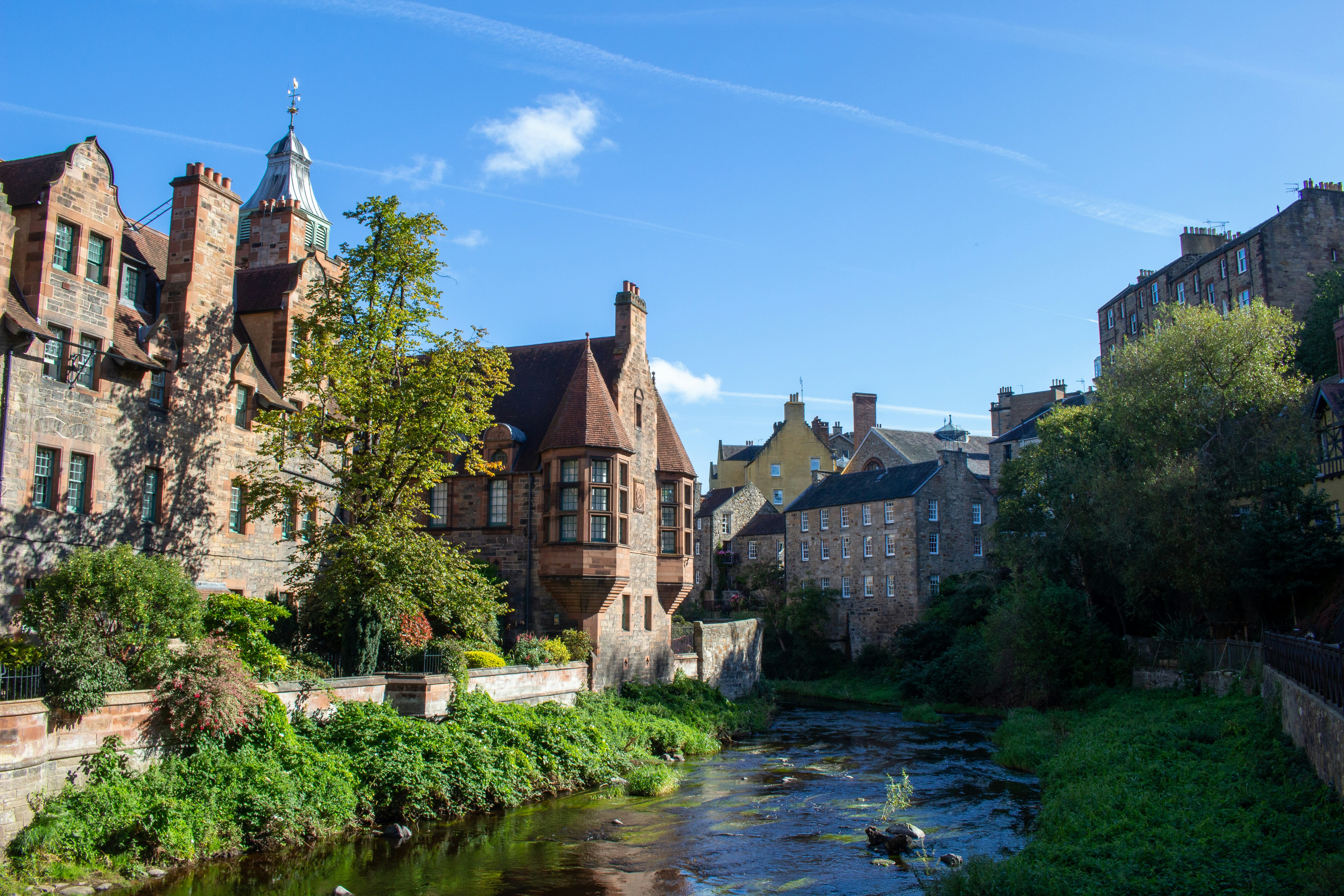 Houses beside a water sewage under a calm blue sky during daytime photo ...