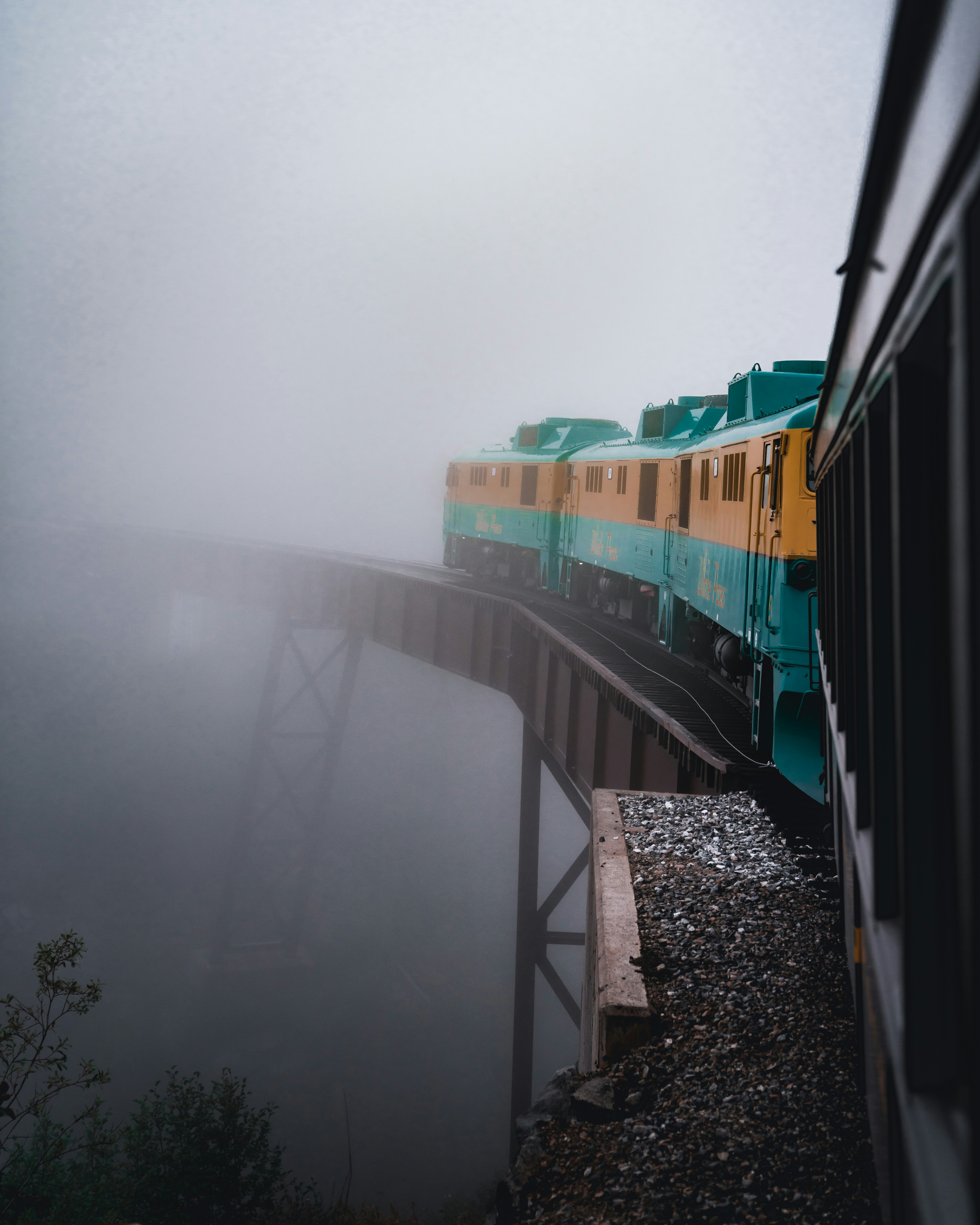 Turquoise and Amber Express on a Mist-Wrapped Bridge