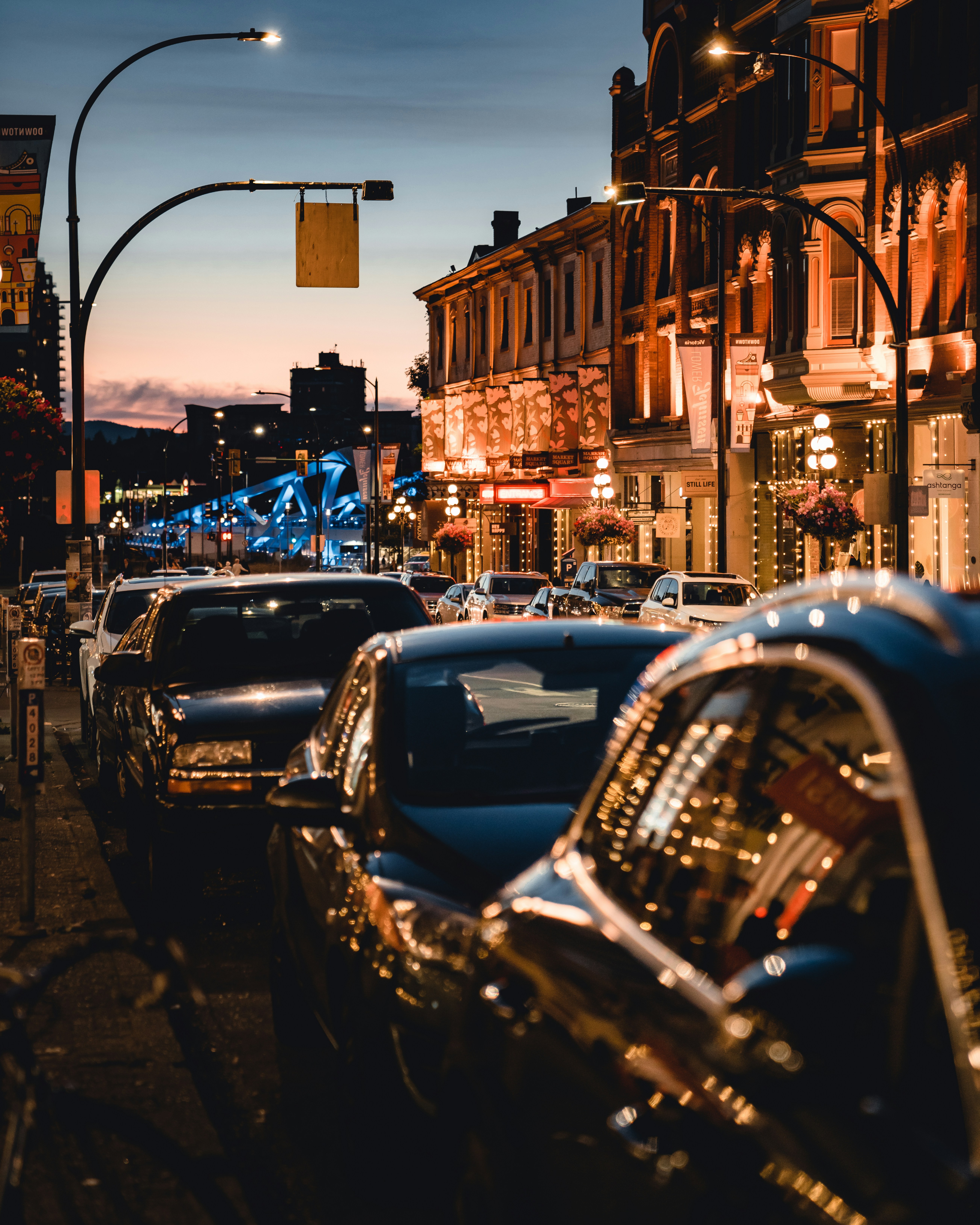 Evening Street Corridor: Neon storefronts, chrome reflections, and a blue-lit promenade