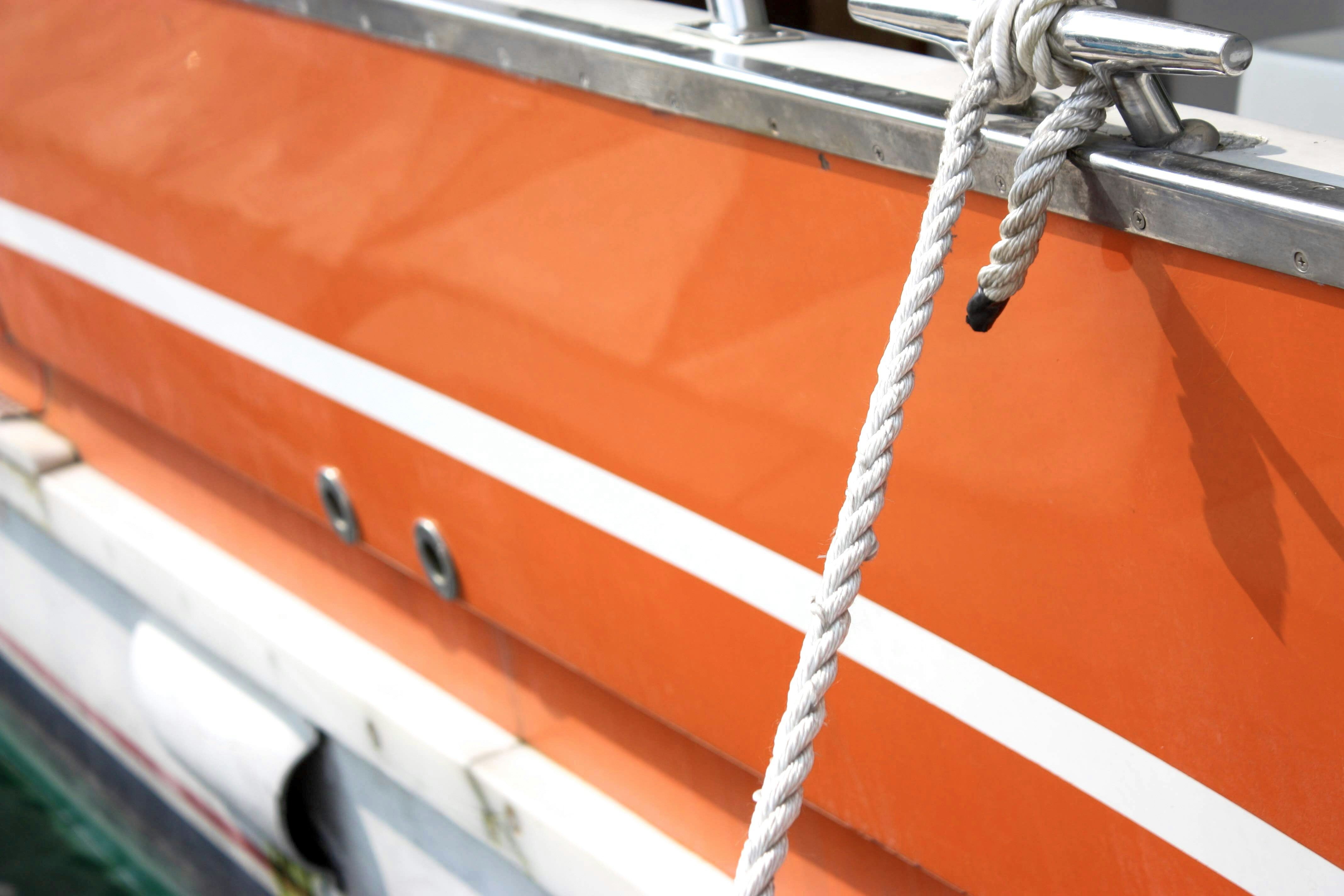 Orange Boat Hull with White Stripe and Mooring Rope
