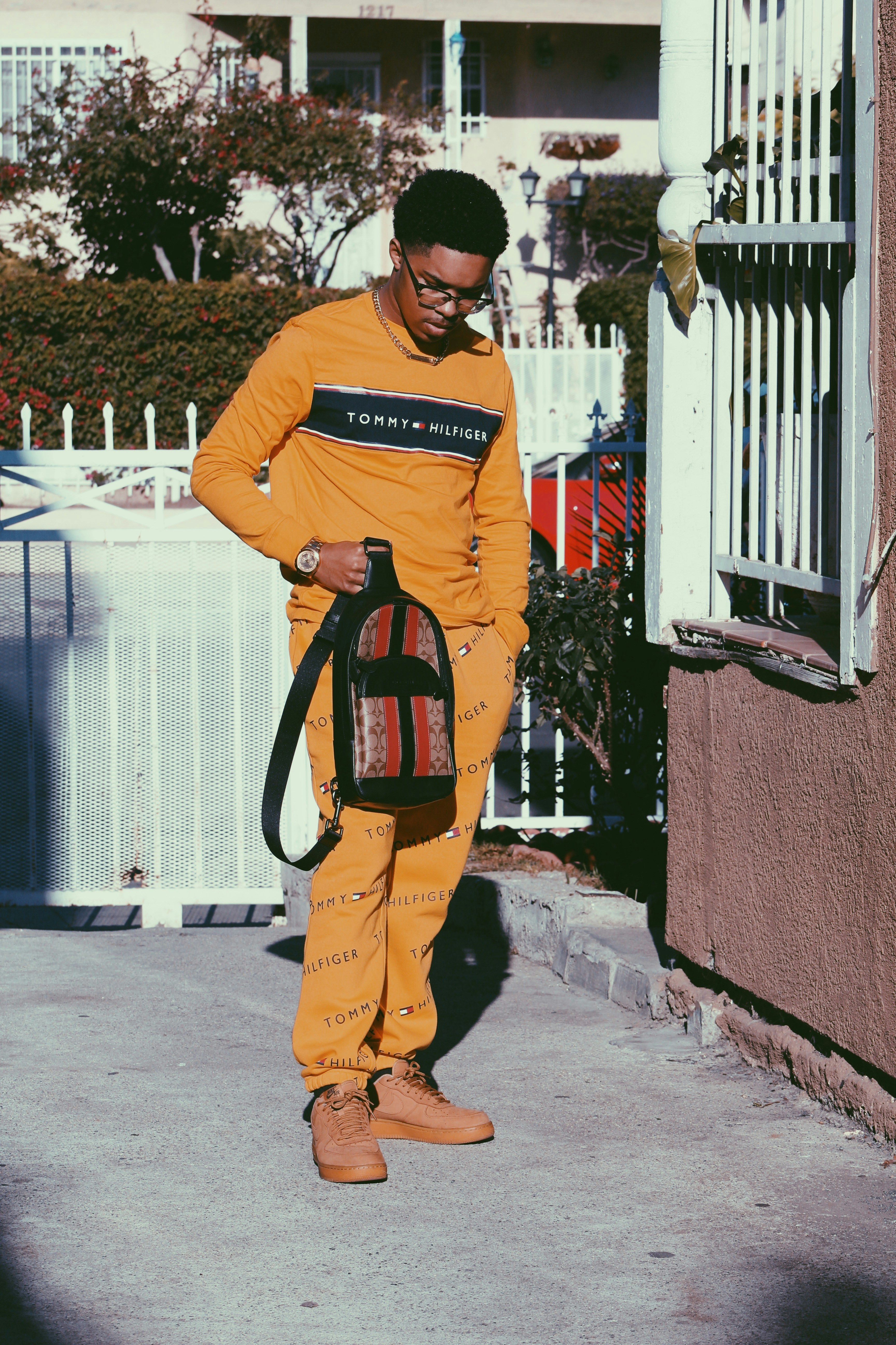 man standing beside house while holding black backpack