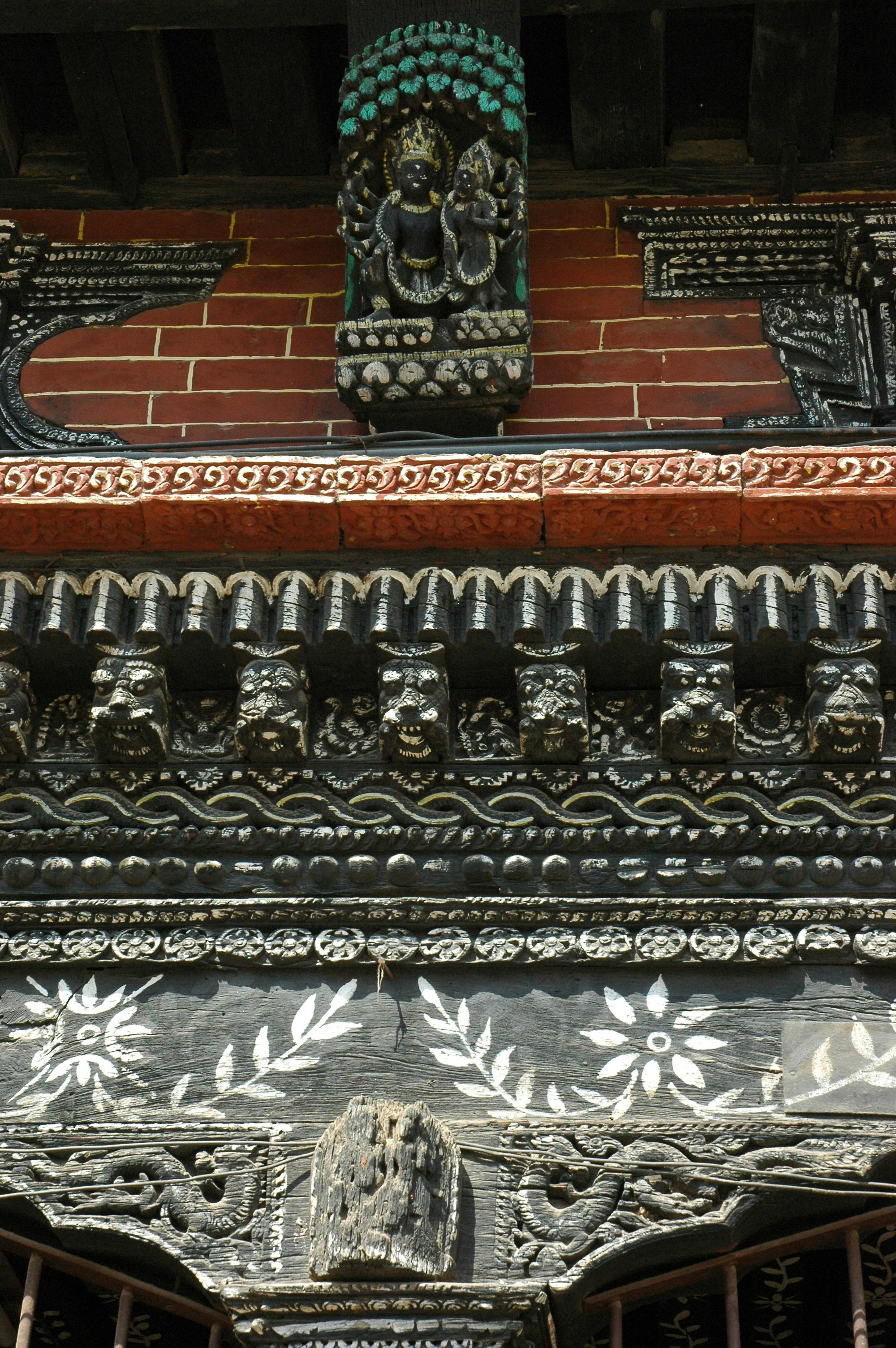 Ornate wooden carvings and vibrant details adorn the facade of a historic structure, showcasing traditional artistry. The craftsmanship reflects cultural significance and heritage.