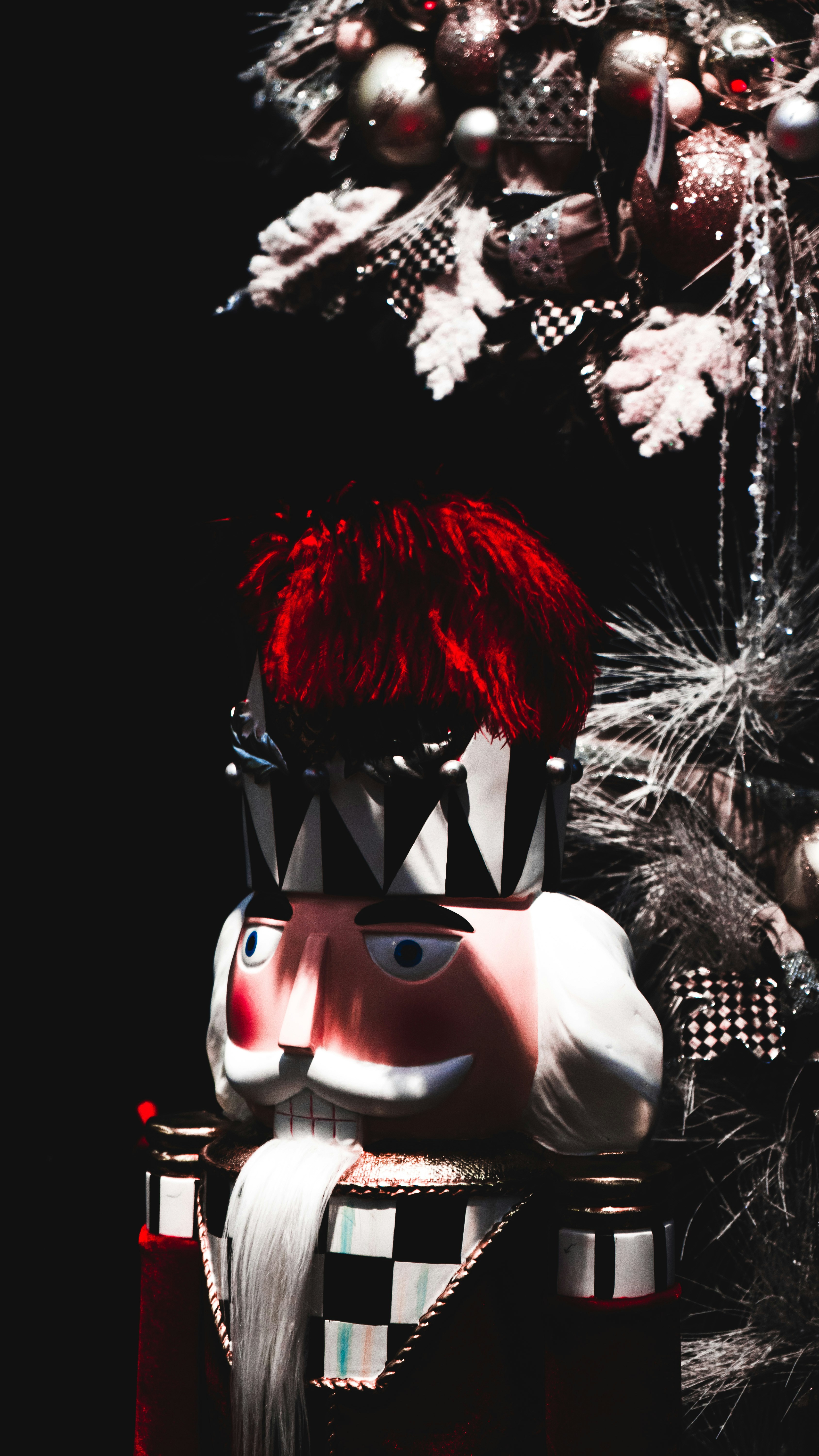 Crimson-Top Nutcracker Beneath a Frosted Tree of Ornaments