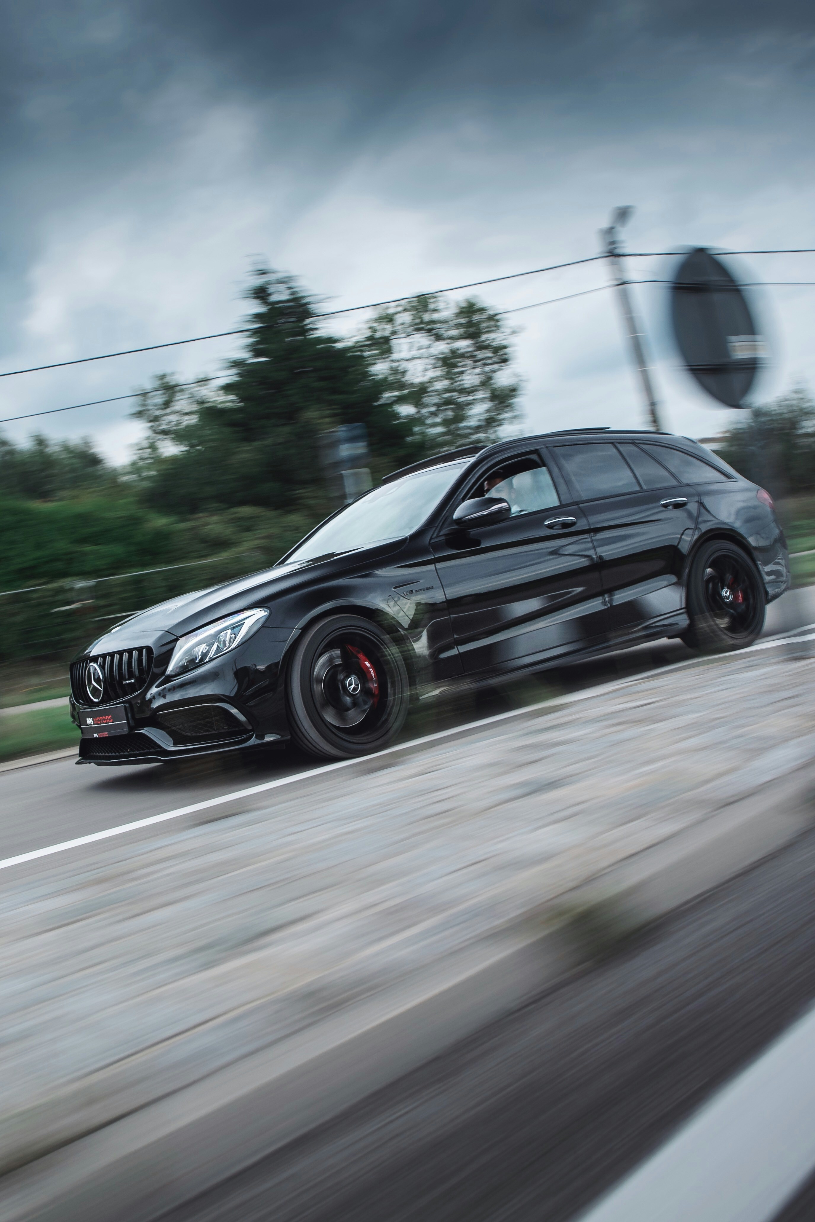Midnight Nitro: A Black Mercedes GLE surges along a rain-damp curbside