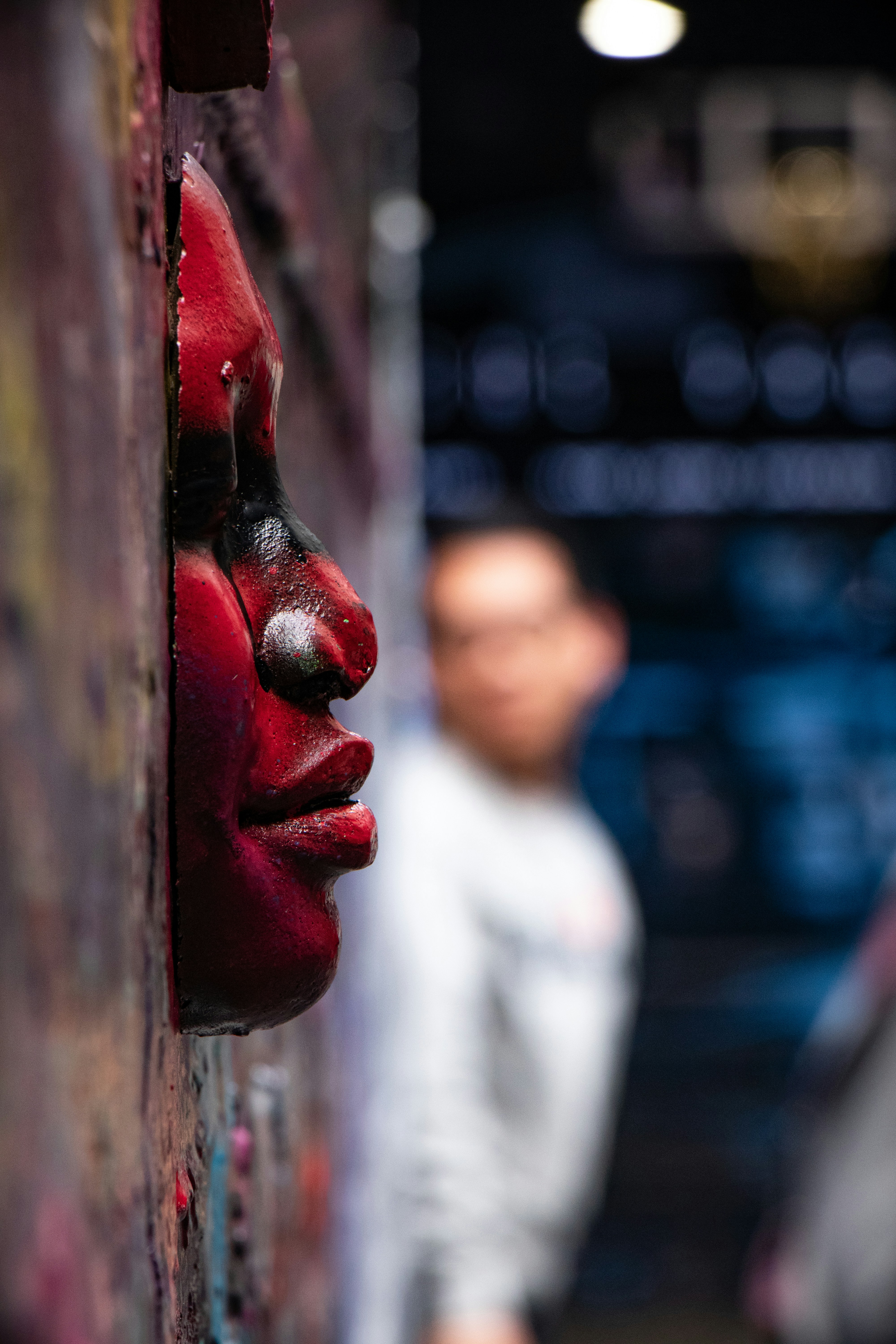 Crimson Lipstone: A Close-Up Sculpture Anchored to a Brick Wall