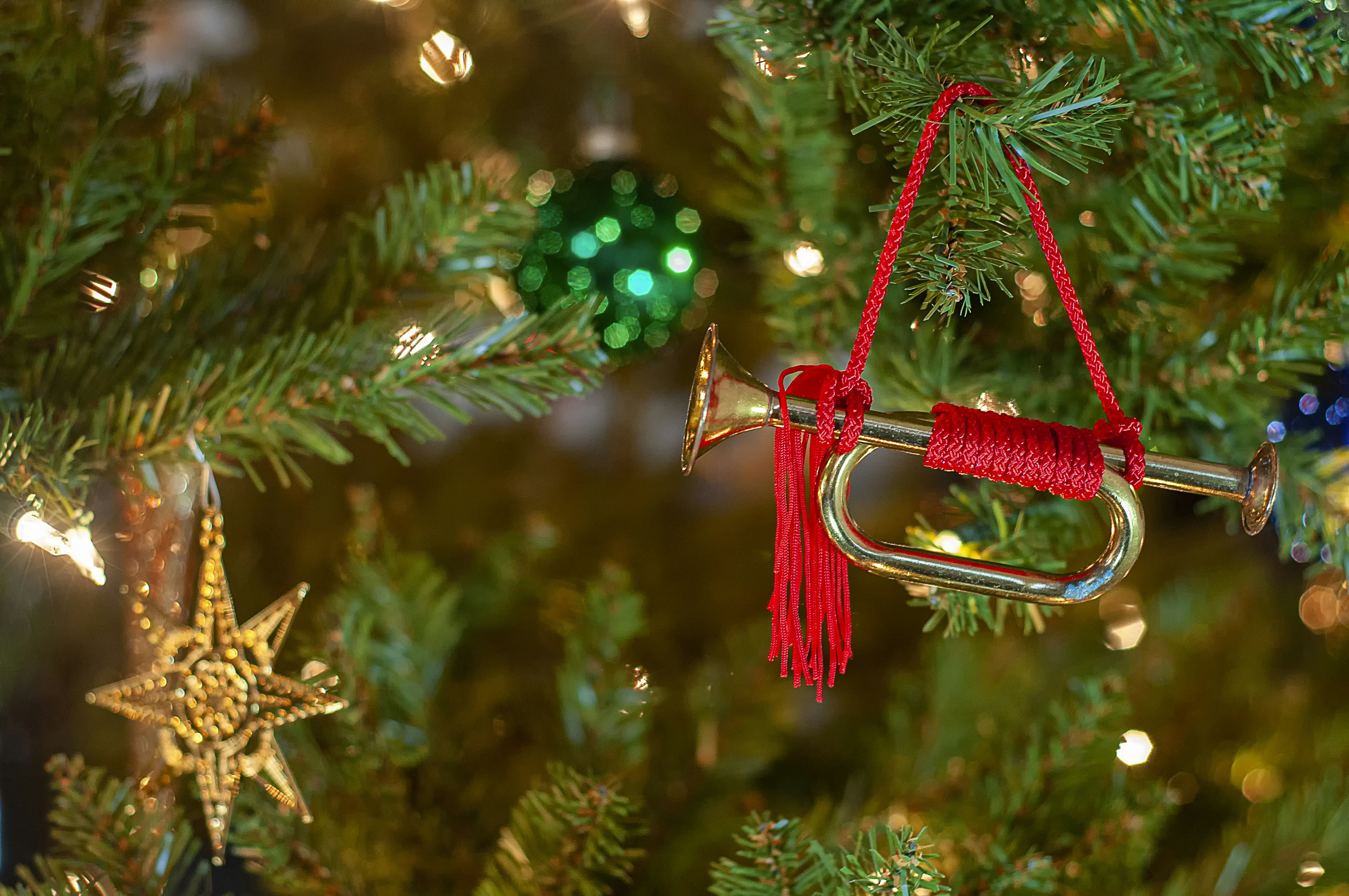 Brass Trumpet Ornament Amid the Glow of Christmas Pines