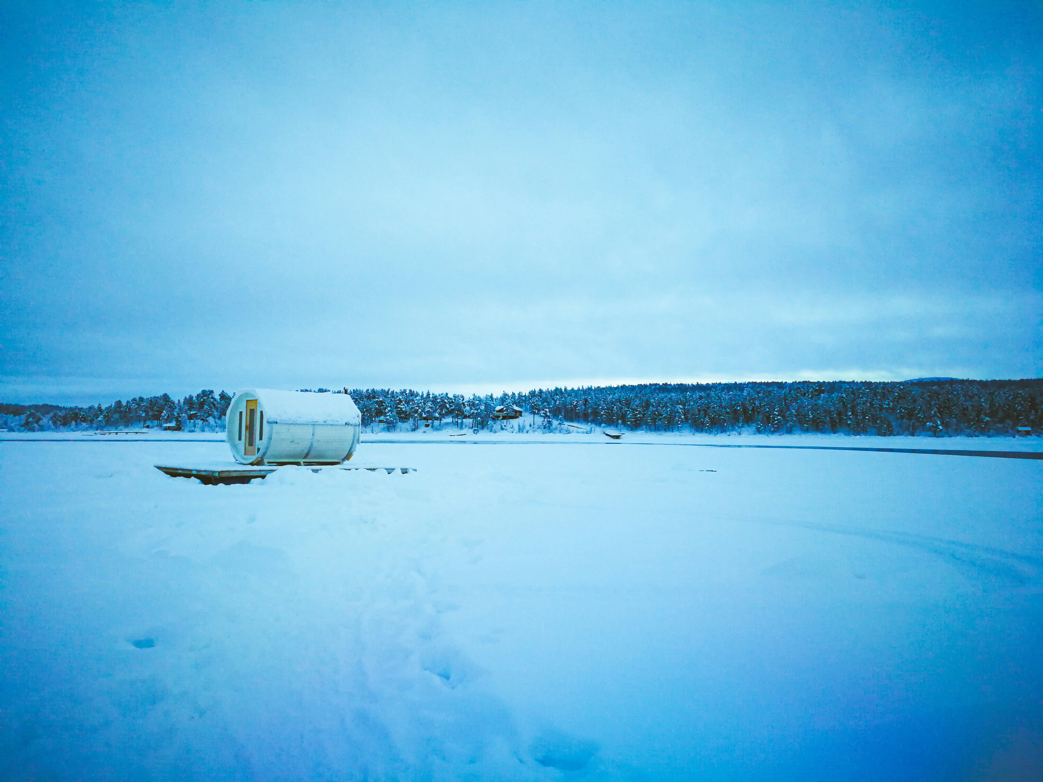 A barrel sitting on top of a snow covered field photo – Free Nature ...