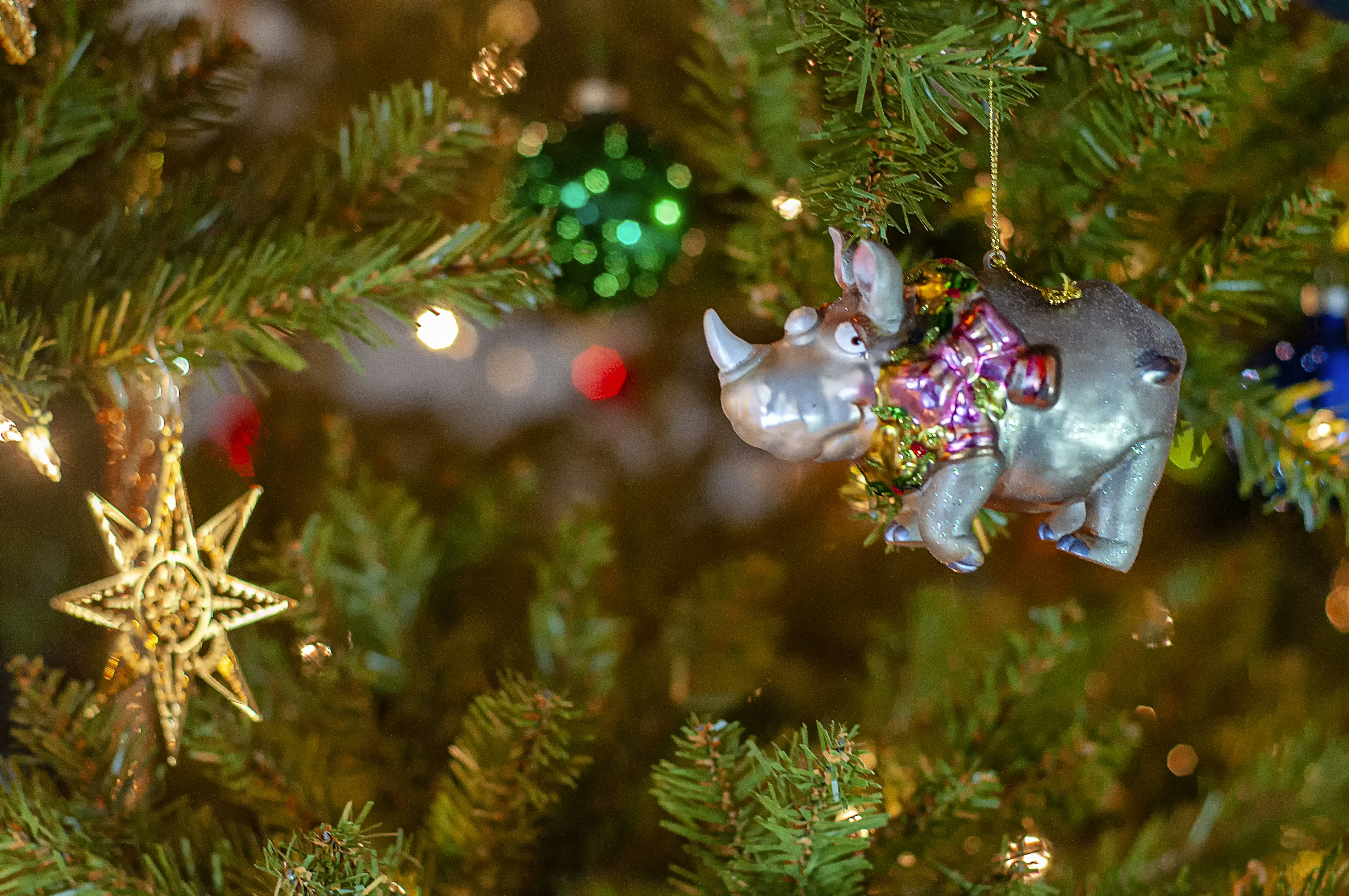 Joyful Ornament: A Tiny Reindeer Dangles from a Warmly Lit Christmas Tree