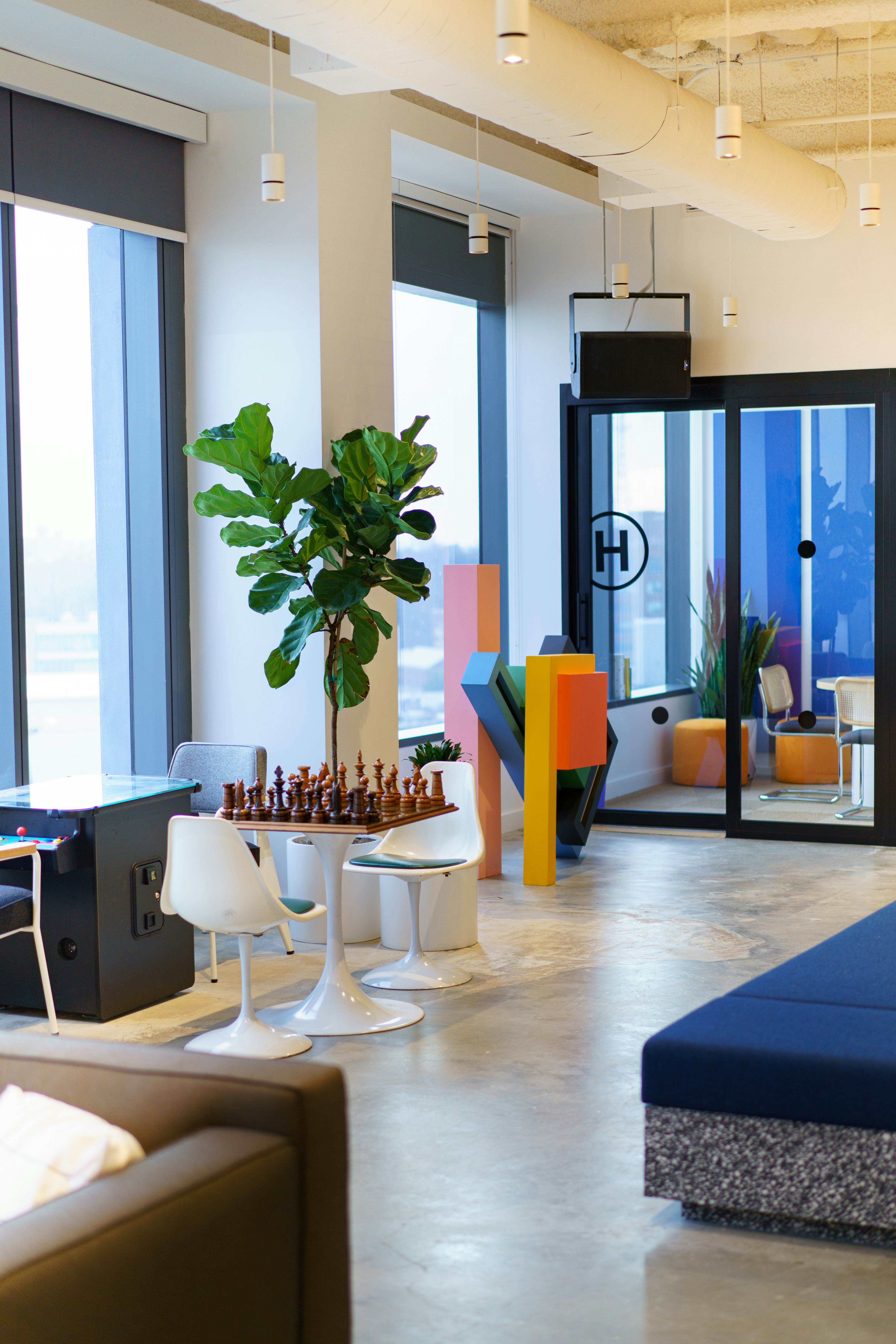 Contemporary office lounge with colorful decor and large windows overlooking a cityscape.