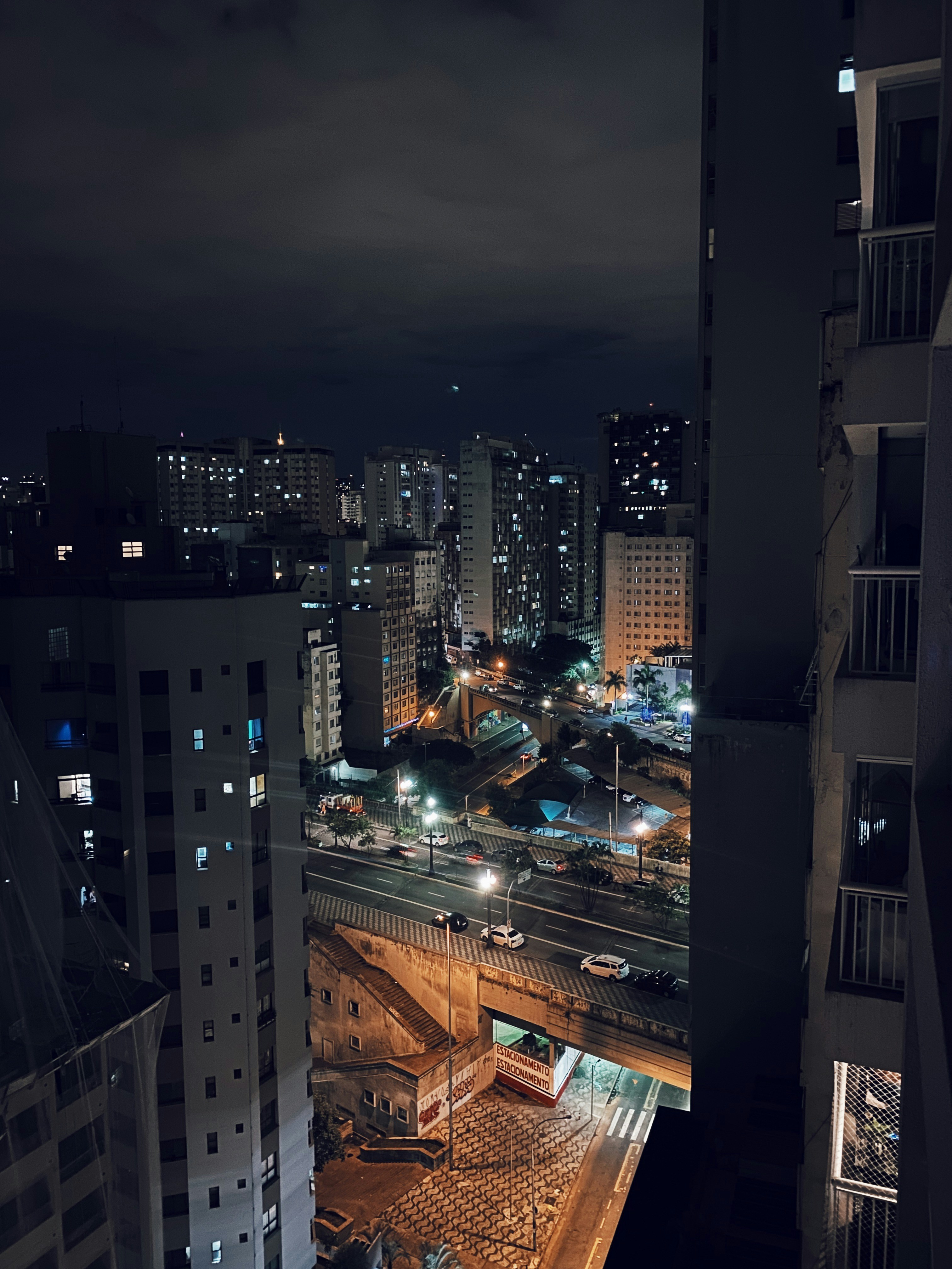 Vibrant city skyline at night, showcasing illuminated buildings and bustling streets below. The scene captures the dynamic energy of urban life after sunset.