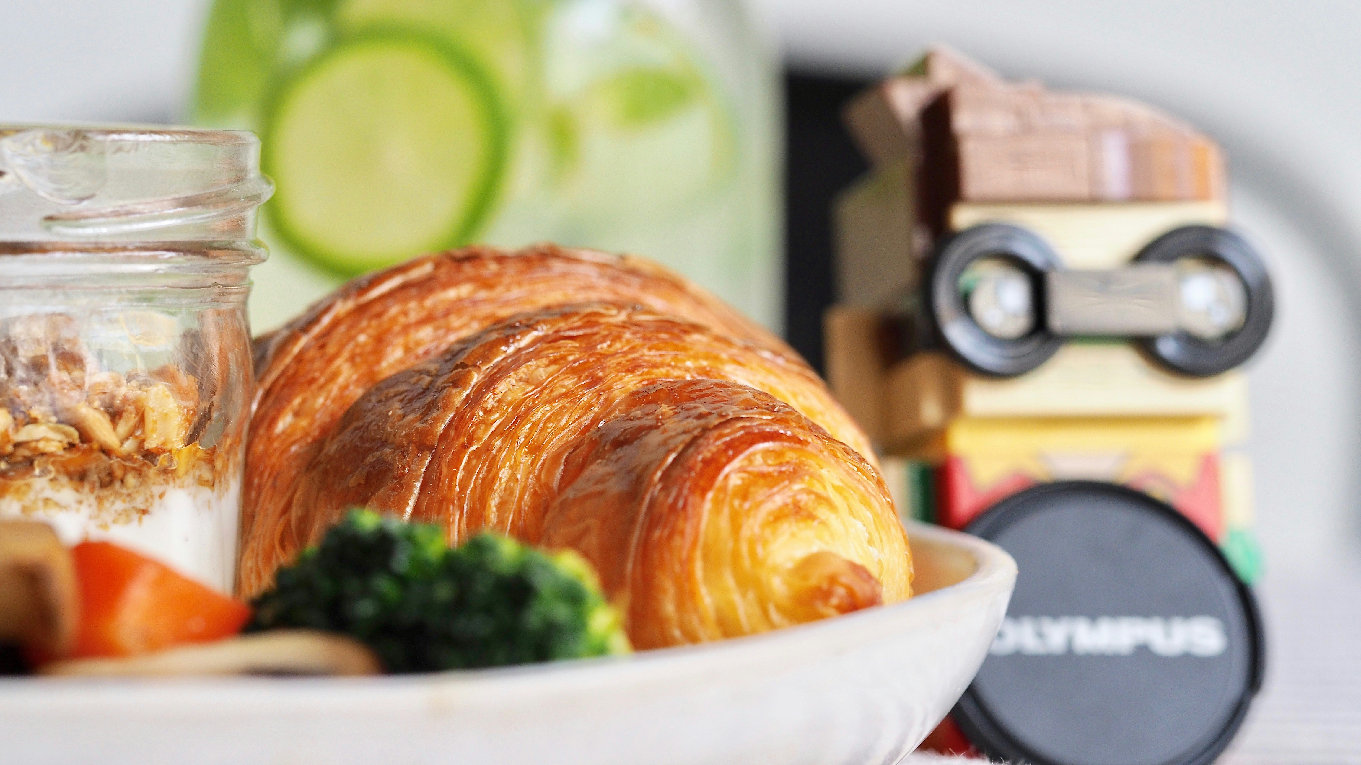 Sunlit Croissant Still Life with Citrus and a Toy Car