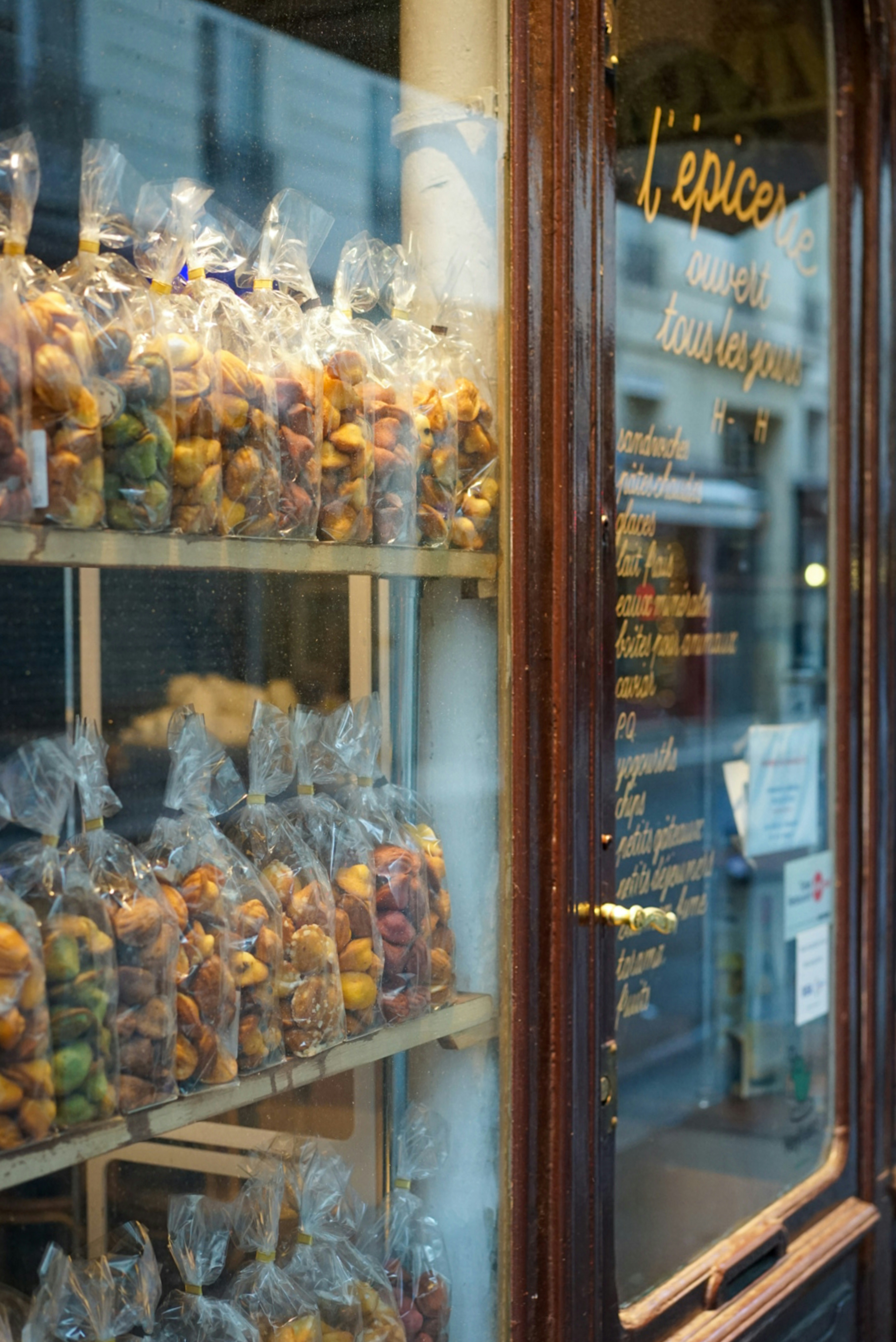 Glass jars of colorful confections beside a pastry shop door
