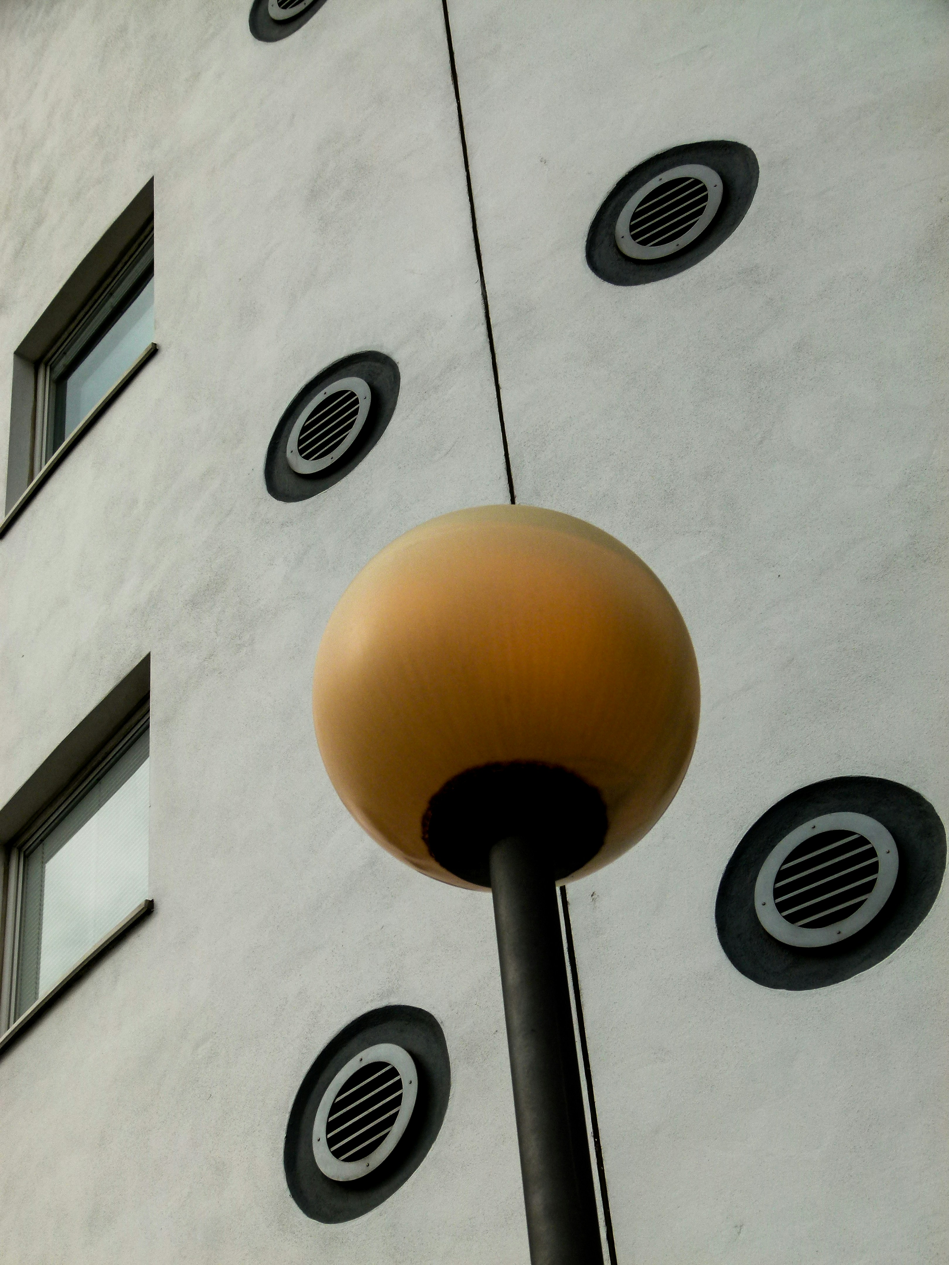Urban Lantern: A Yellow Sphere Against concrete Geometry